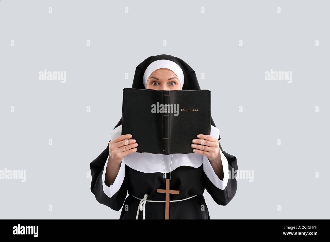 Shocked mature nun with Holy Bible on light background Stock Photo - Alamy