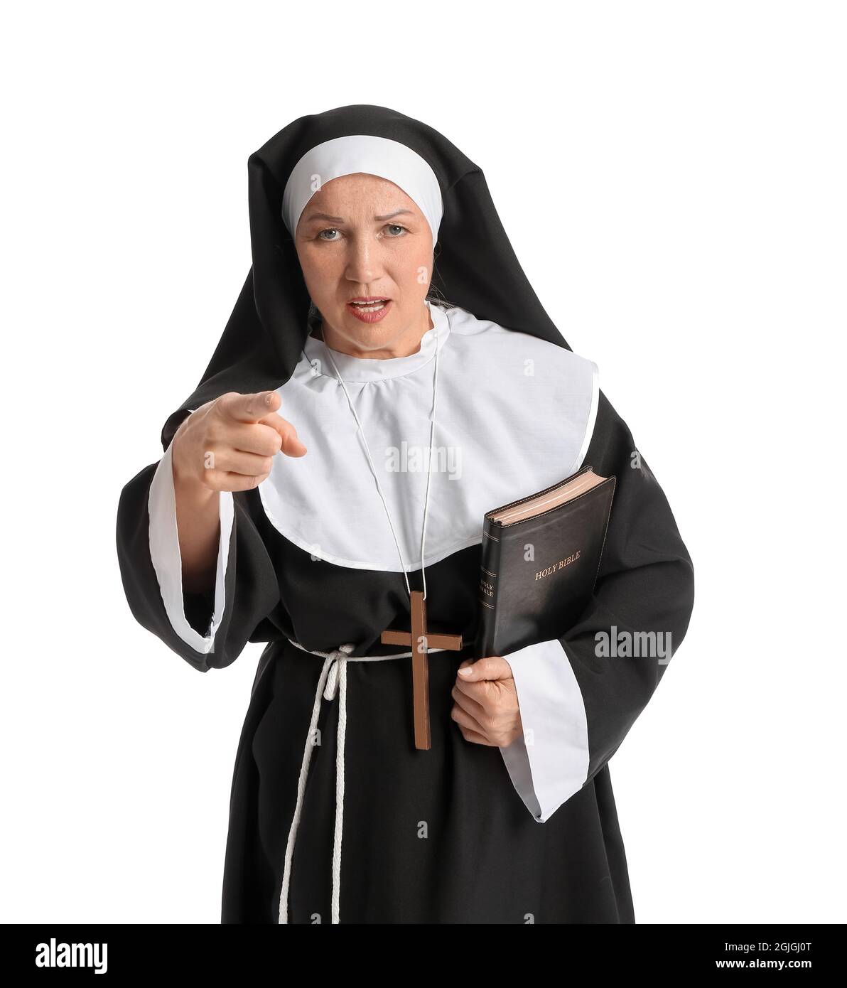 Mature nun with Holy Bible pointing at viewer on white background Stock ...