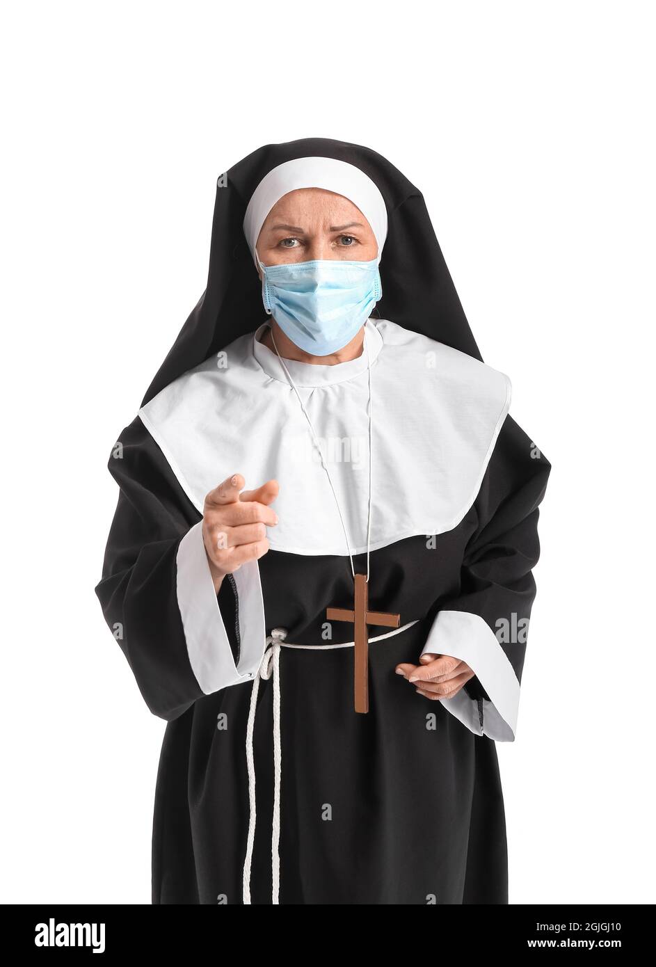 Mature nun in medical mask pointing at viewer on white background Stock ...