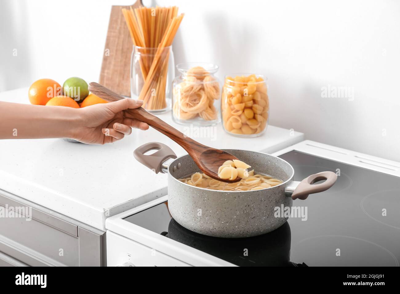 Woman cooking pasta in kitchen Stock Photo - Alamy