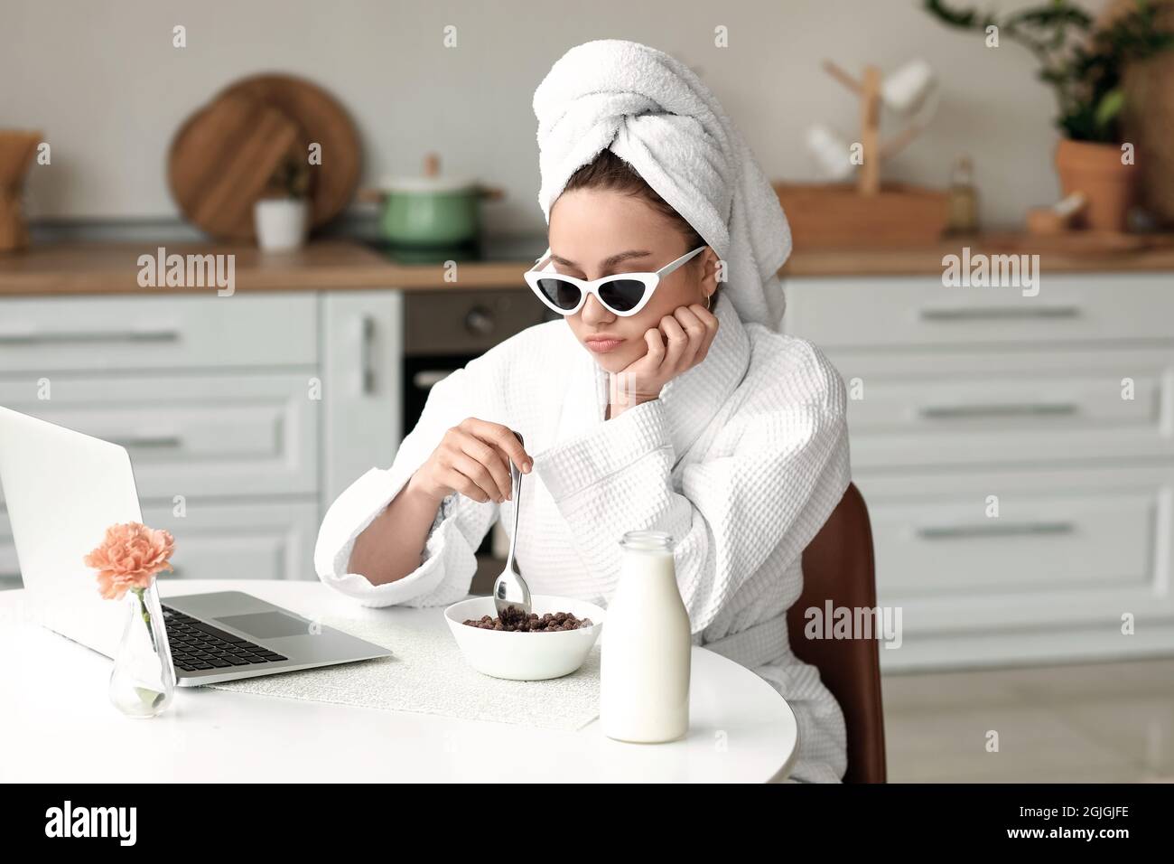 Bored young woman having breakfast at home Stock Photo - Alamy