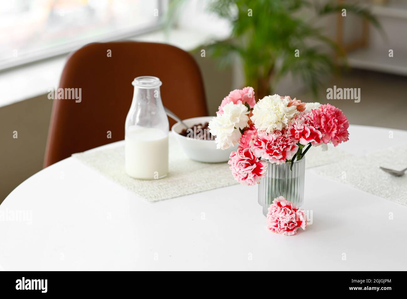 Vase with flowers on dining table in kitchen Stock Photo - Alamy