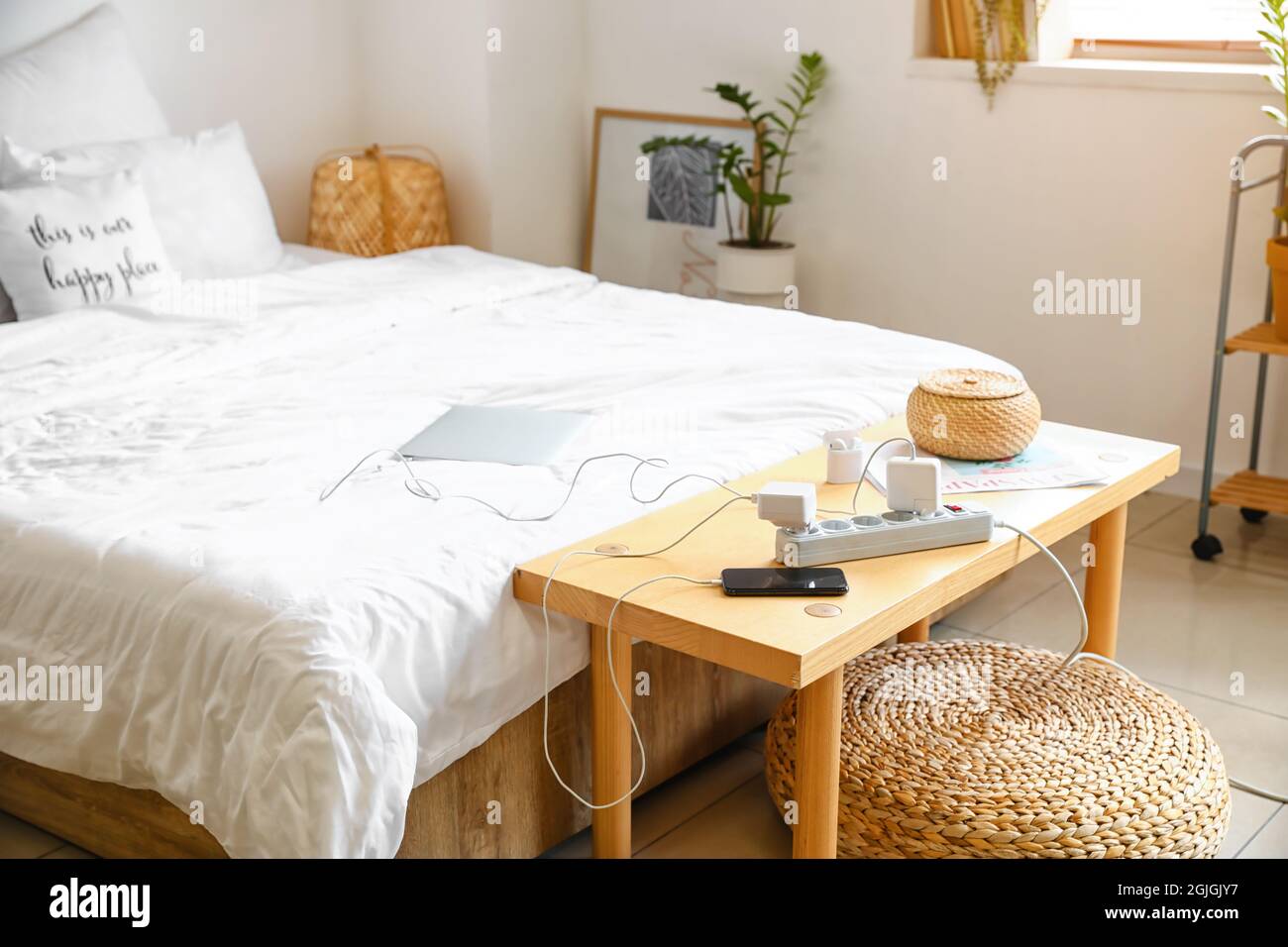 Extension cord with charging gadgets on table in bedroom Stock Photo ...
