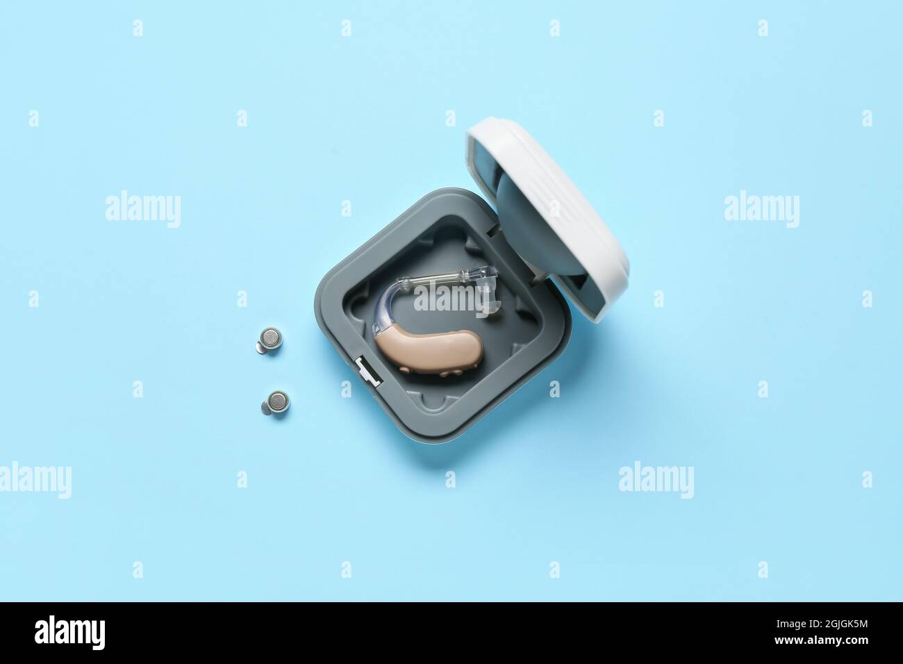 Box with hearing aid on color background Stock Photo - Alamy