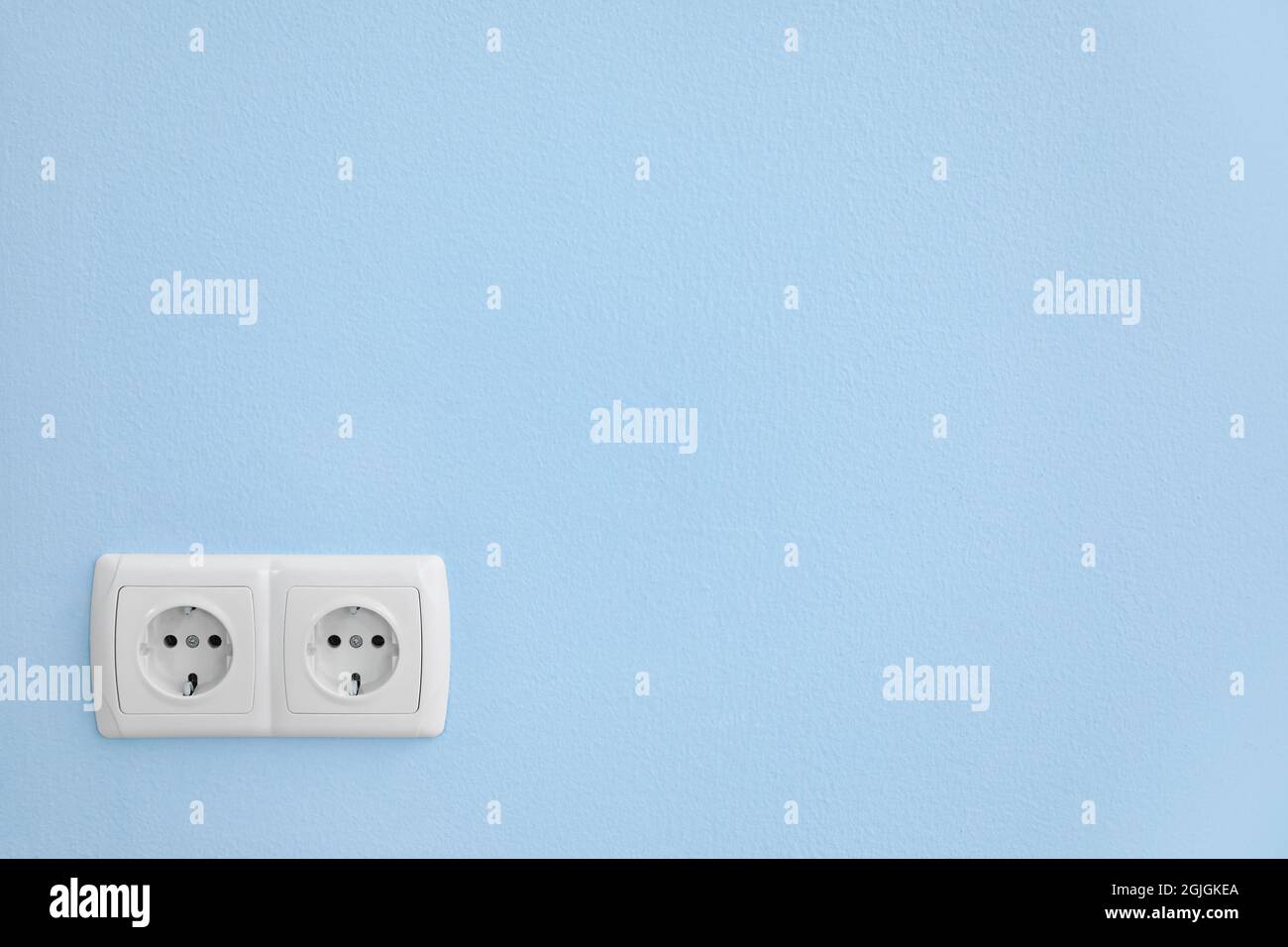 Electric socket on color wall Stock Photo - Alamy