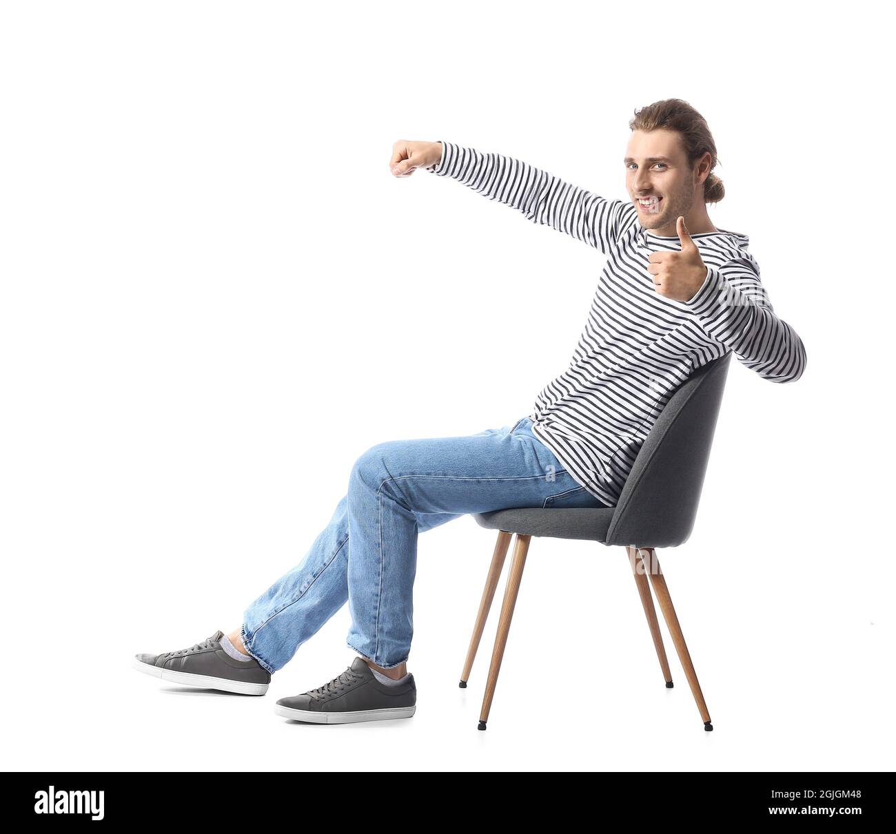 Young man with imaginary steering wheel showing thumb-up on white ...