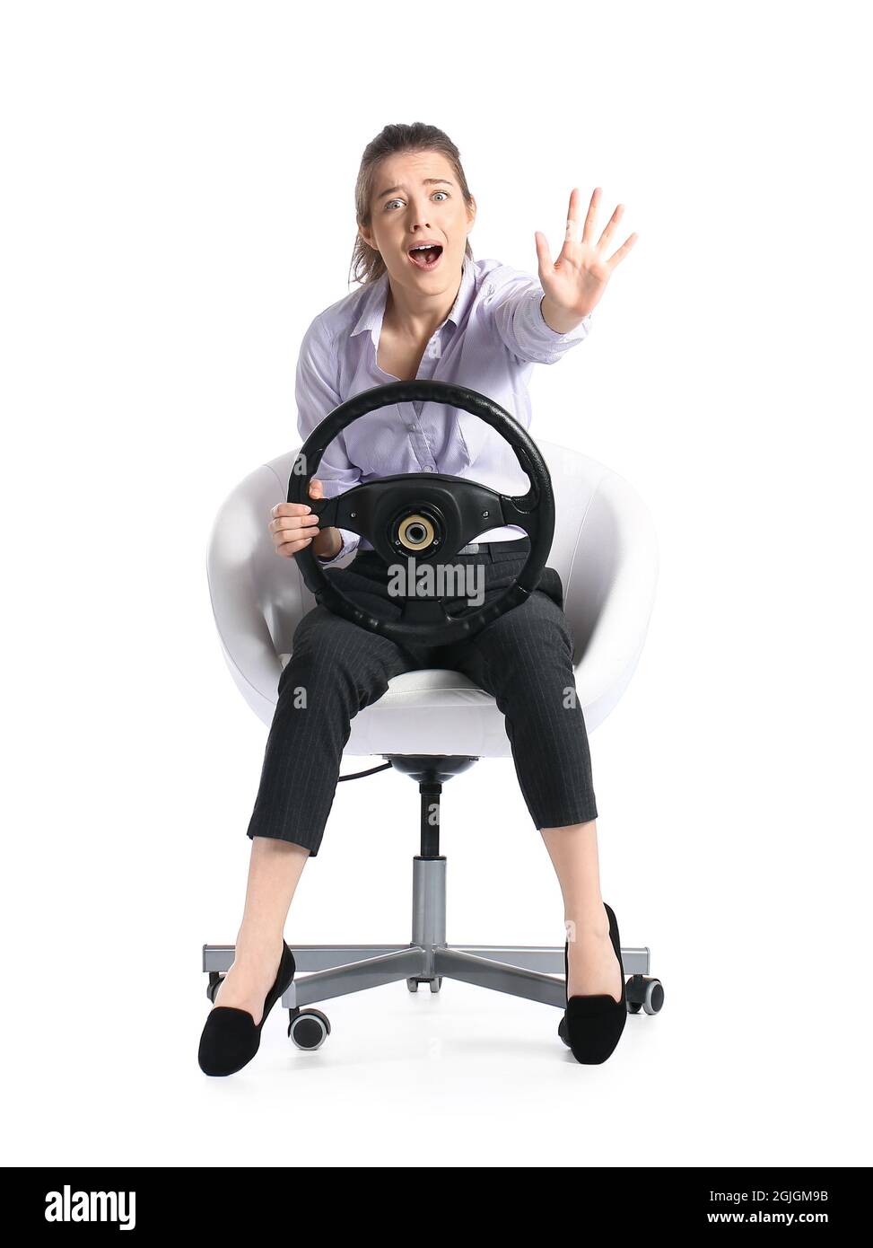 Shocked young woman with steering wheel sitting in chair on white ...