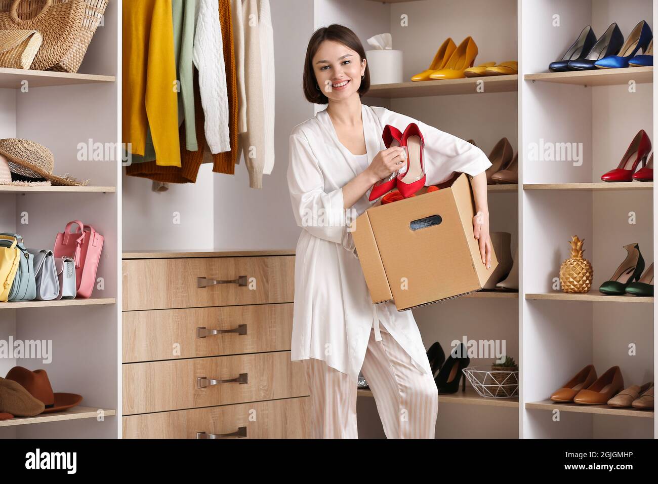 Young woman arranging clothes at wardrobe Stock Photo - Alamy