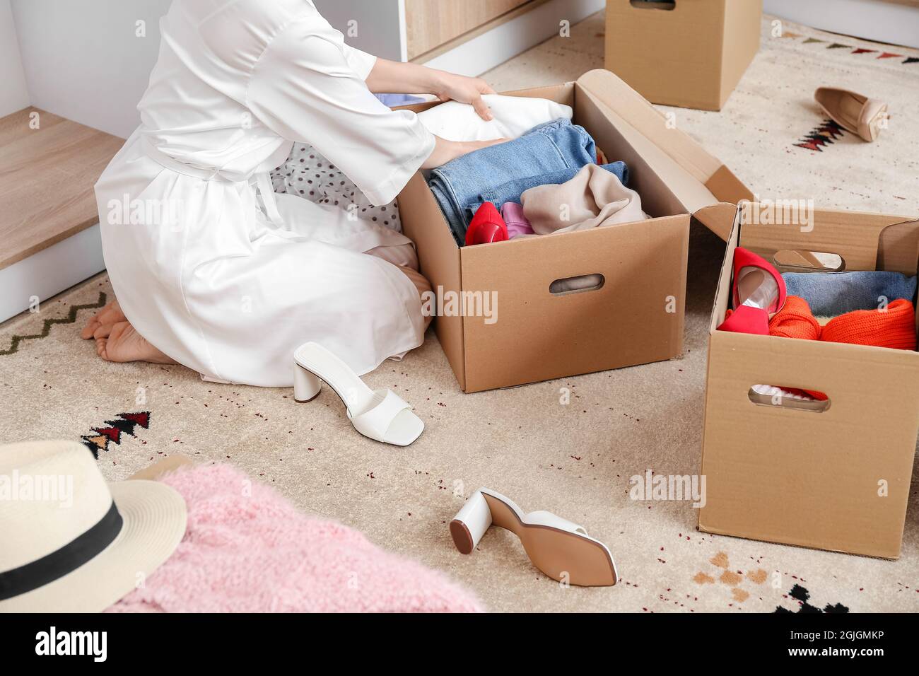 Young woman arranging clothes at wardrobe Stock Photo - Alamy