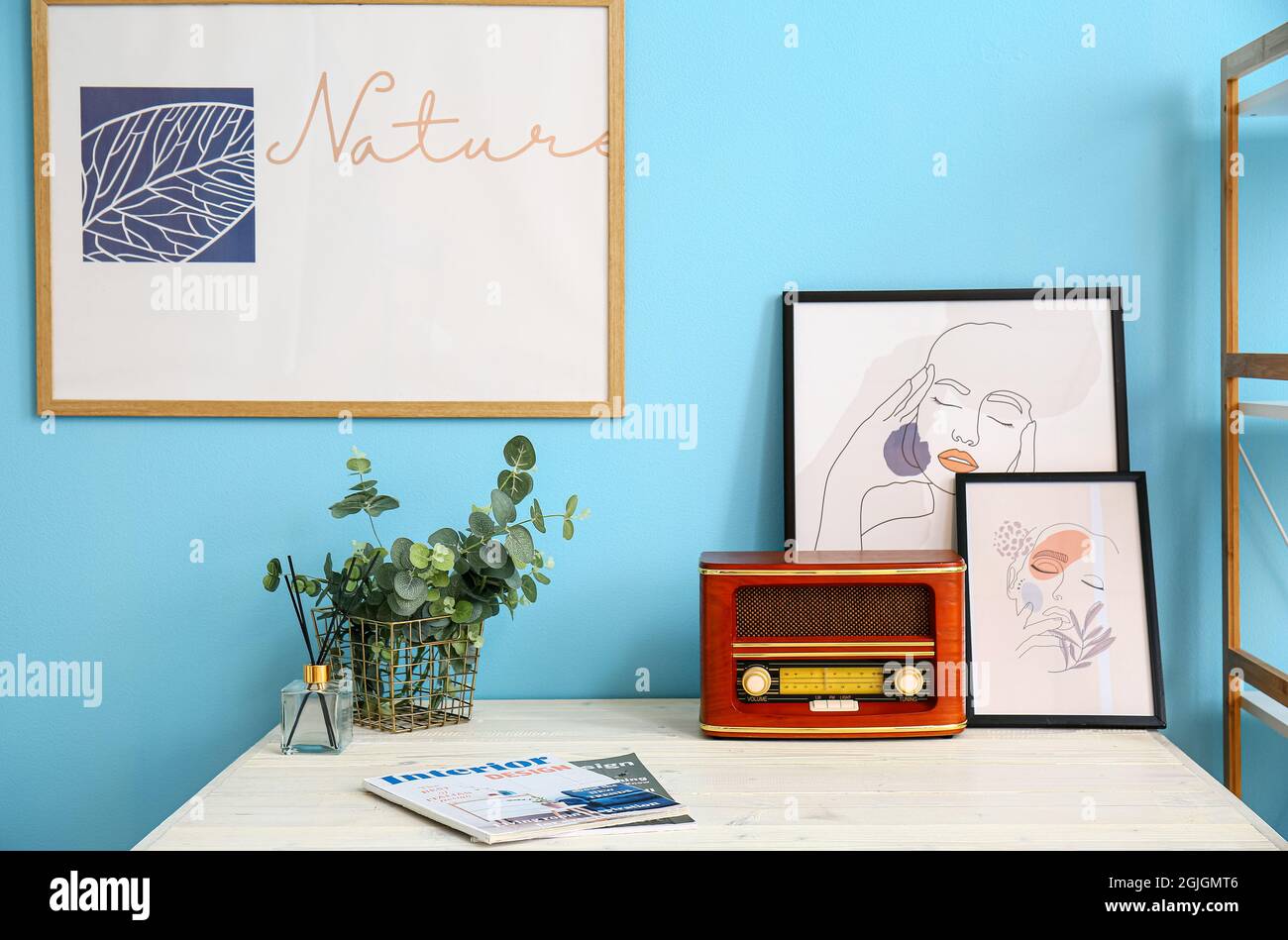 Table with retro radio receiver and pictures near color wall Stock ...