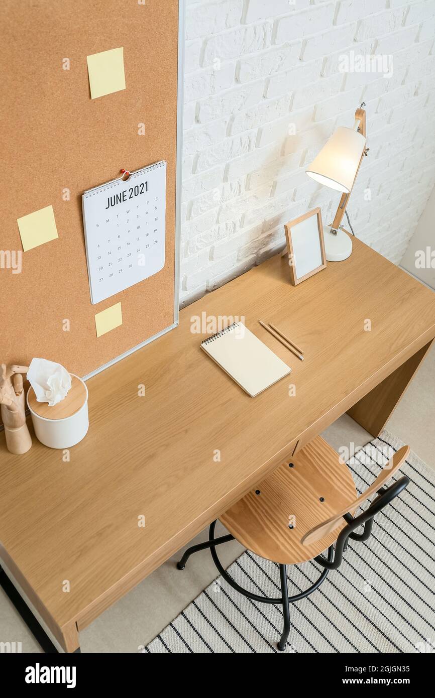 Modern workplace with sticker board near brick wall Stock Photo - Alamy