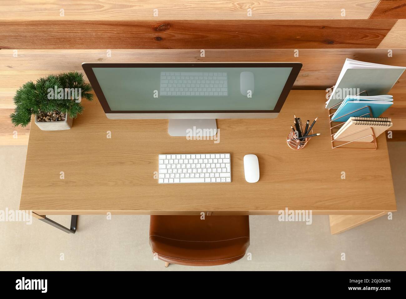 Modern workplace with computer near wooden wall Stock Photo - Alamy