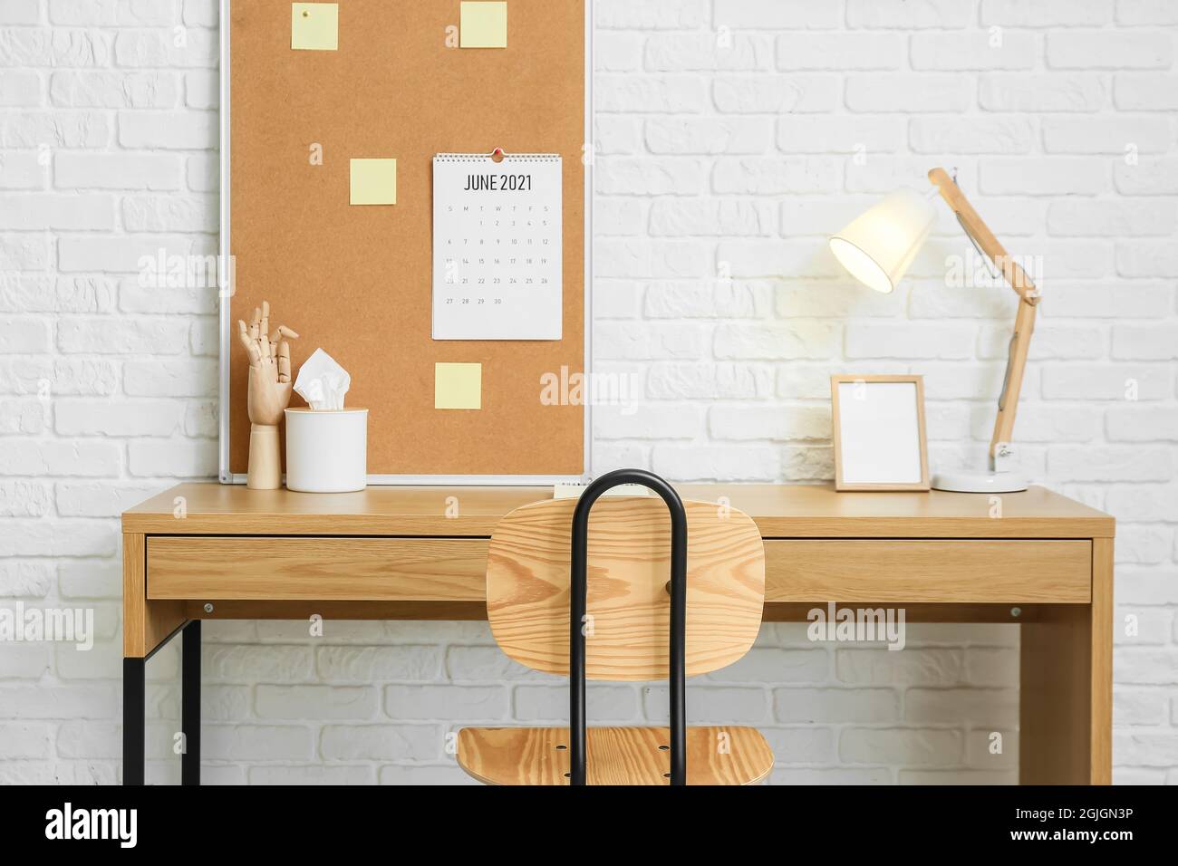 Modern workplace with sticker board near brick wall Stock Photo - Alamy