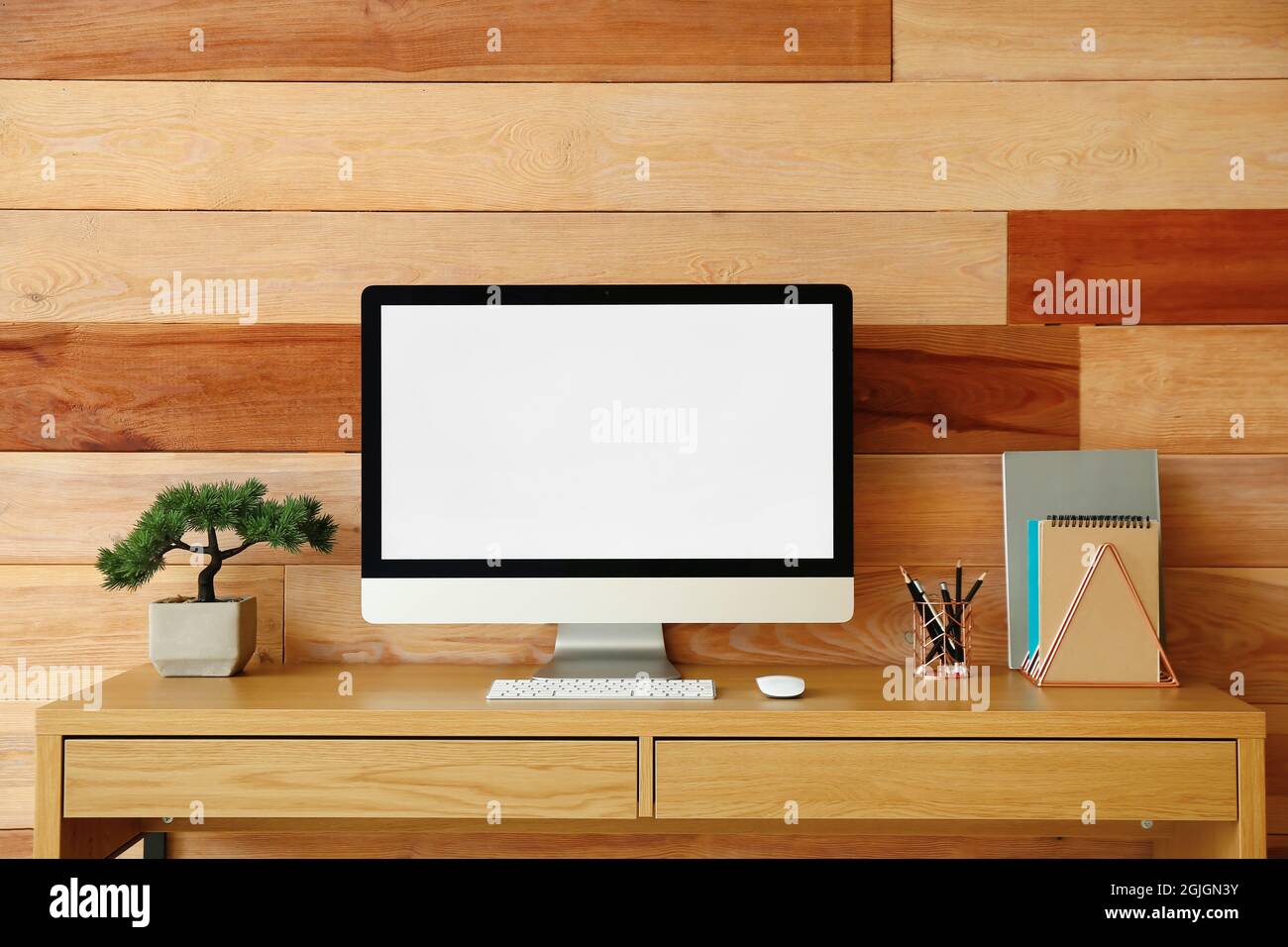 Modern workplace with computer near wooden wall Stock Photo - Alamy