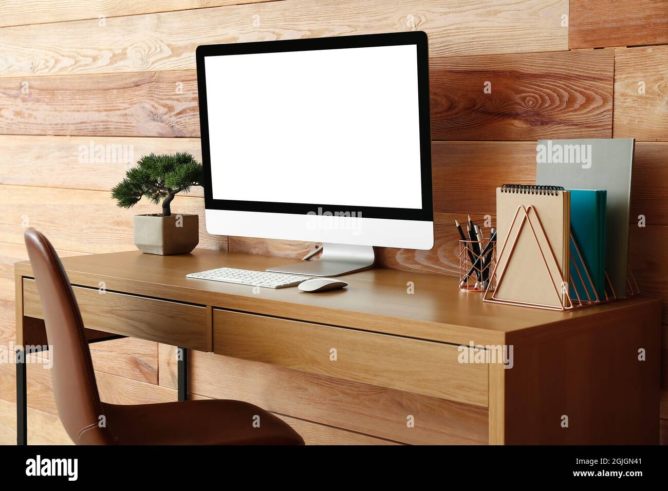 Modern workplace with computer near wooden wall Stock Photo - Alamy