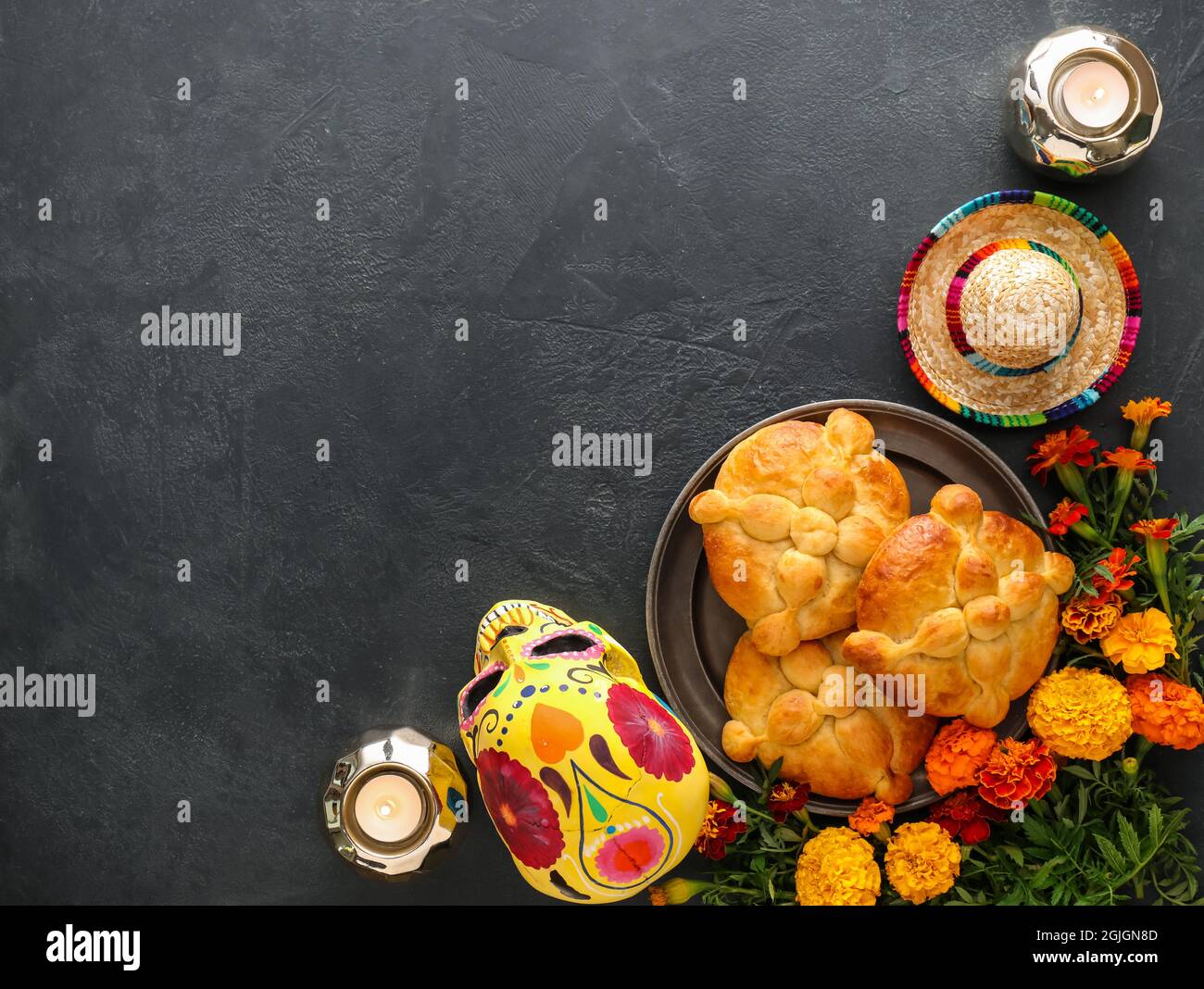Bread of the dead, sombrero hat and painted skull on dark background ...