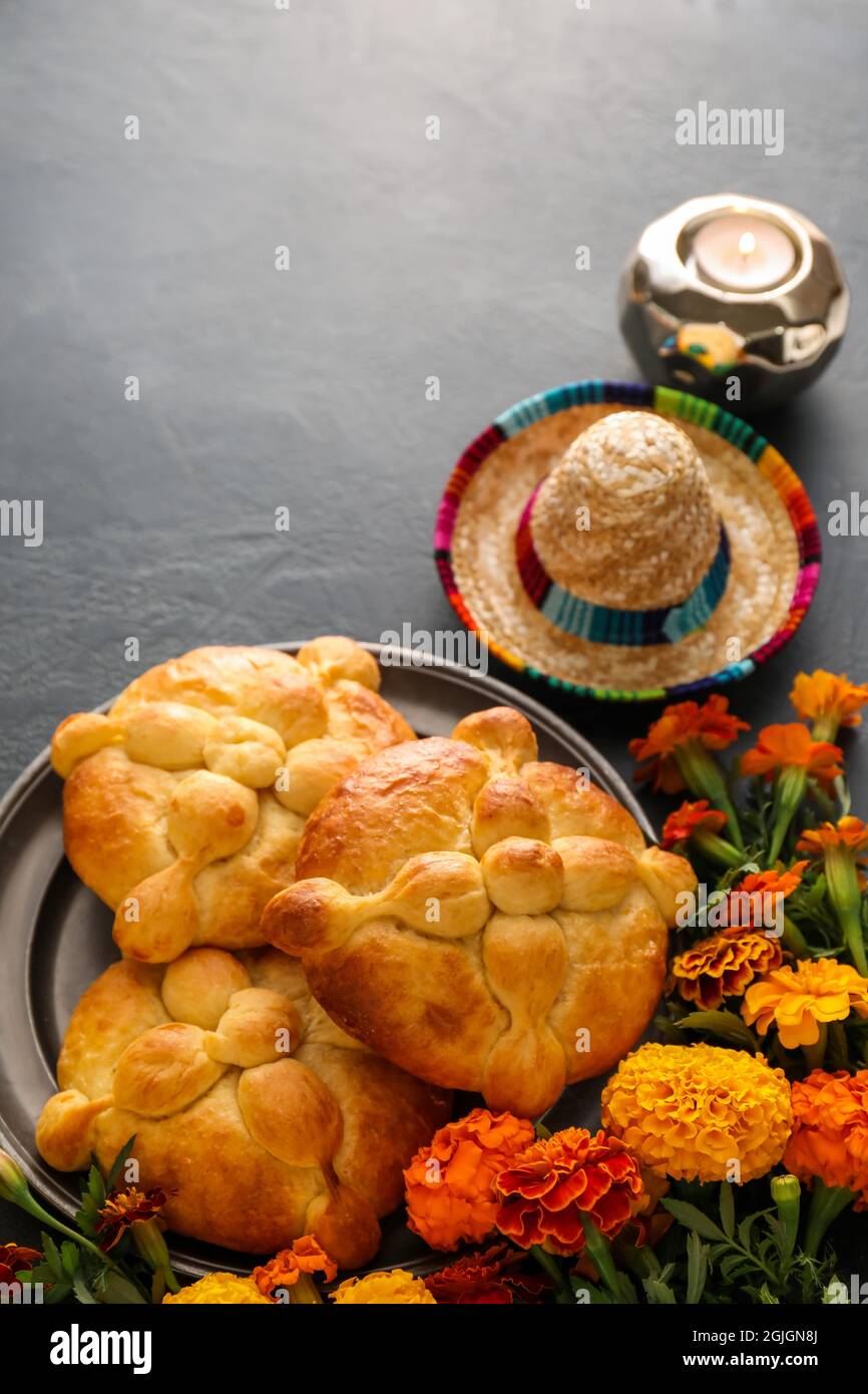 Bread of the dead, sombrero hat and marigold flowers on dark background ...