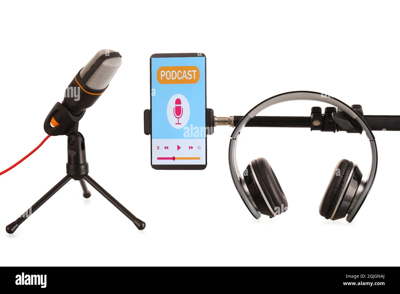 Modern microphone with headphones and mobile phone with podcast ...