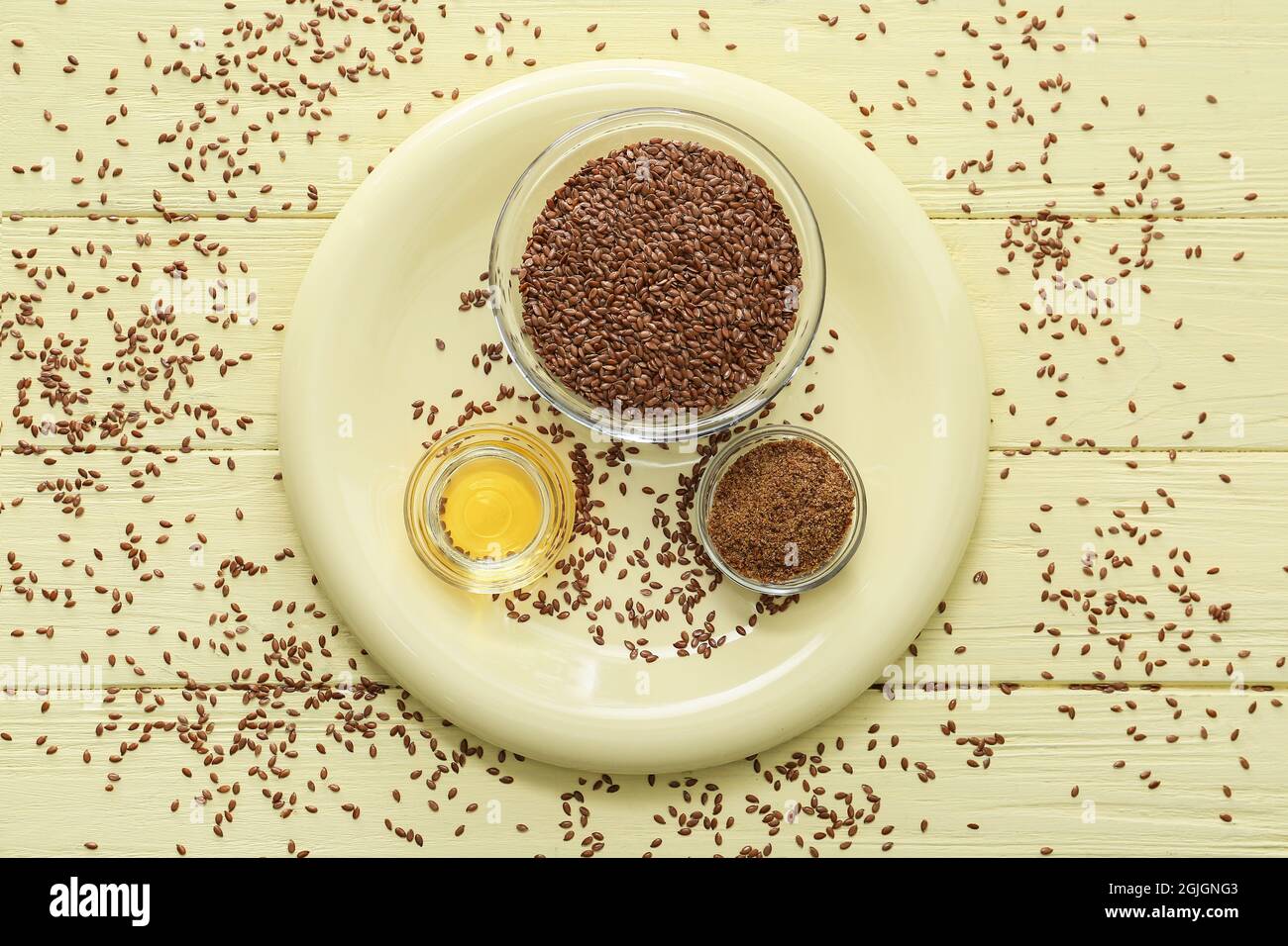 Bowls with flax seeds and oil on color wooden background Stock Photo - Alamy