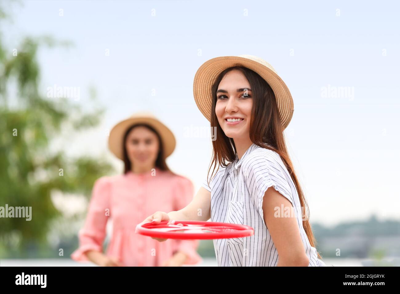 Beautiful young women playing frisbee outdoors Stock Photo - Alamy