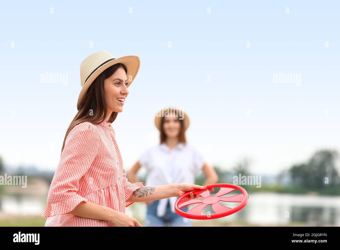 Beautiful young women playing frisbee outdoors Stock Photo - Alamy