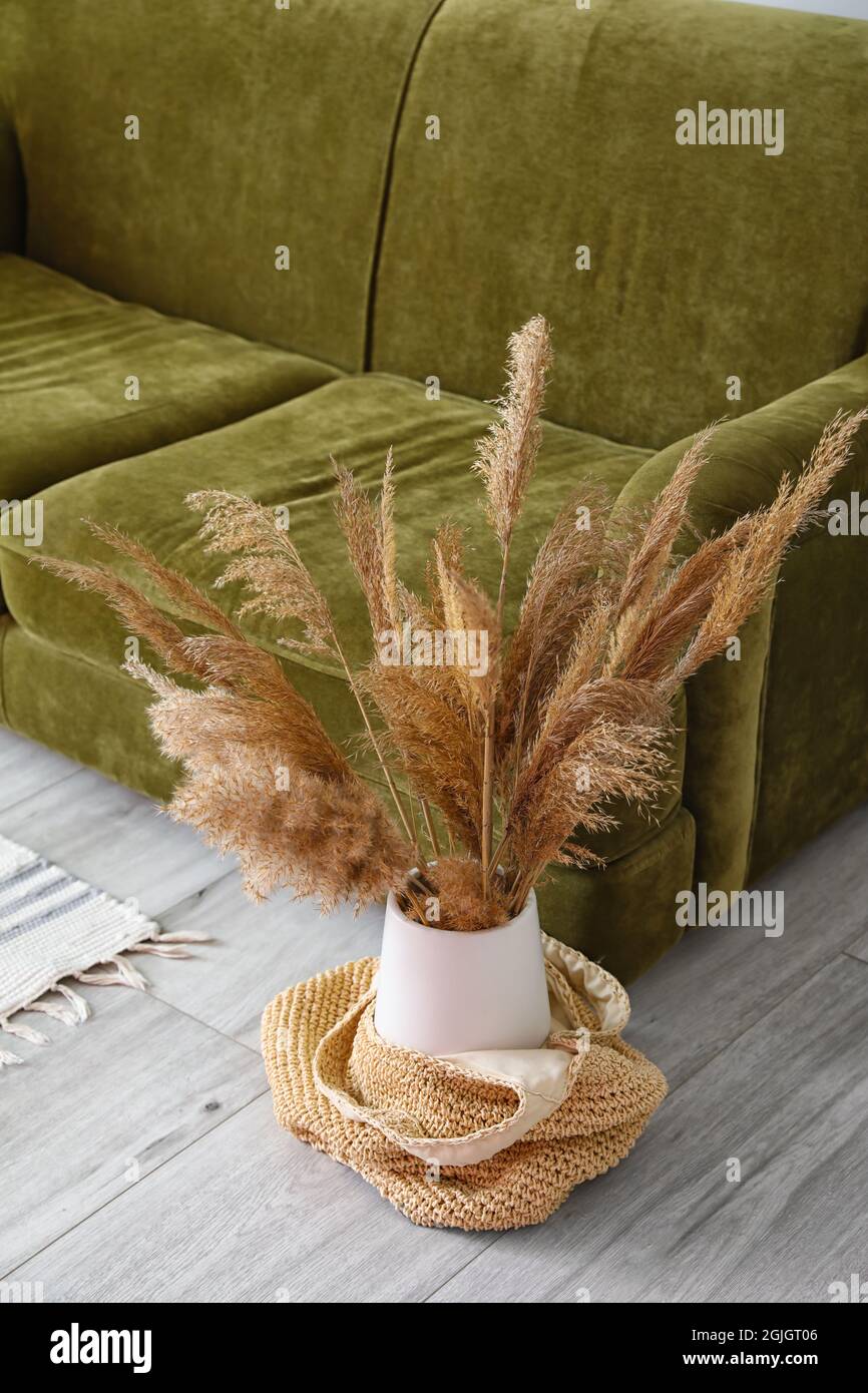 Vase with dry reeds on floor in room Stock Photo - Alamy