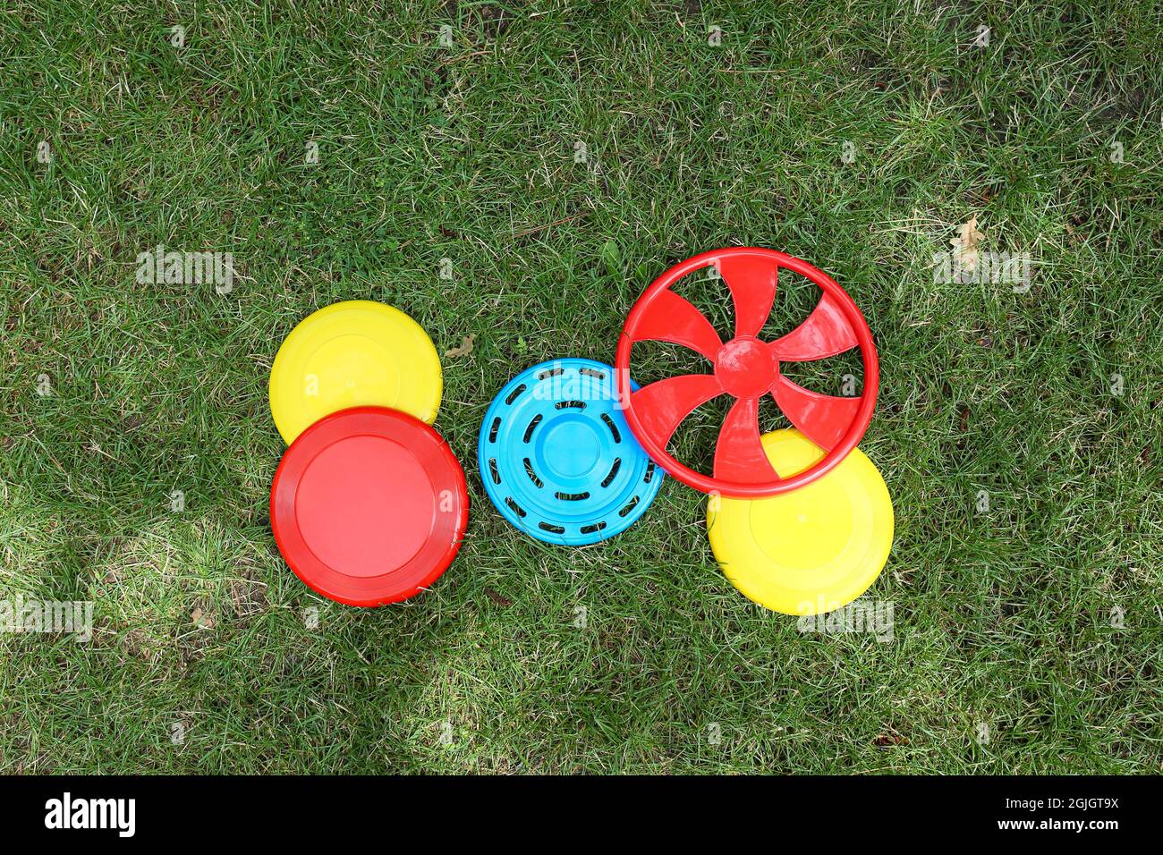 Different frisbee disks on grass outdoors Stock Photo - Alamy