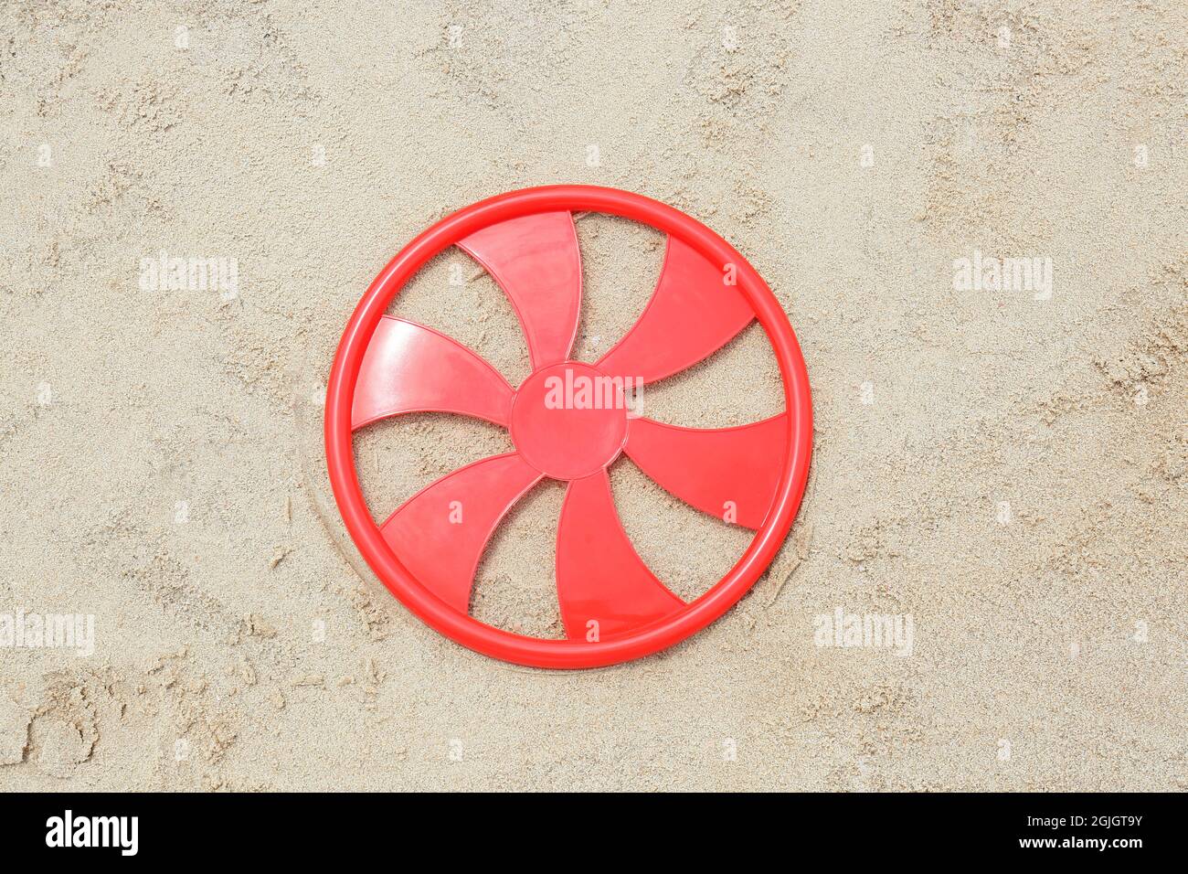 Red frisbee disk on sand Stock Photo - Alamy