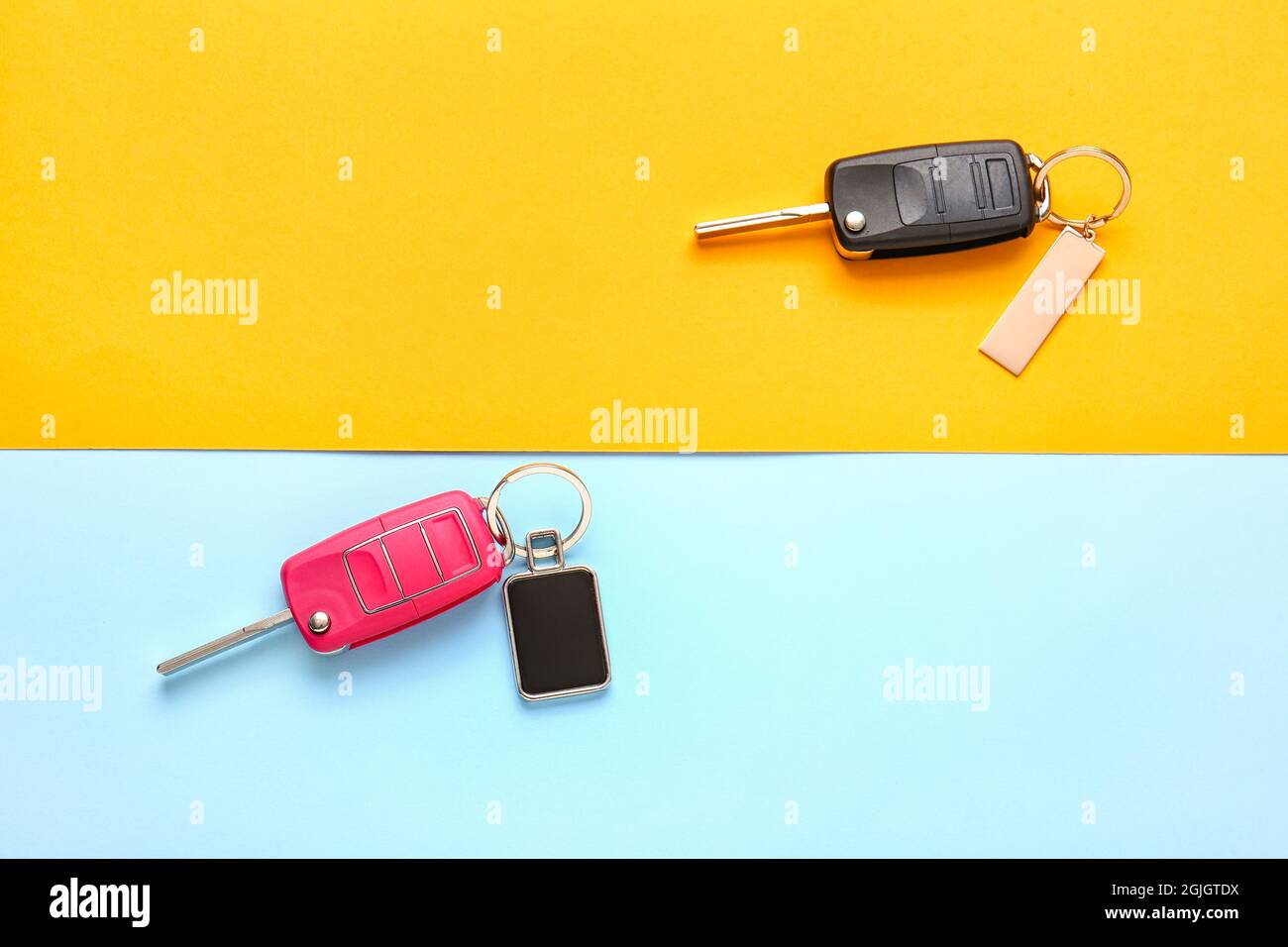 Car keys with stylish keychains on color background Stock Photo - Alamy