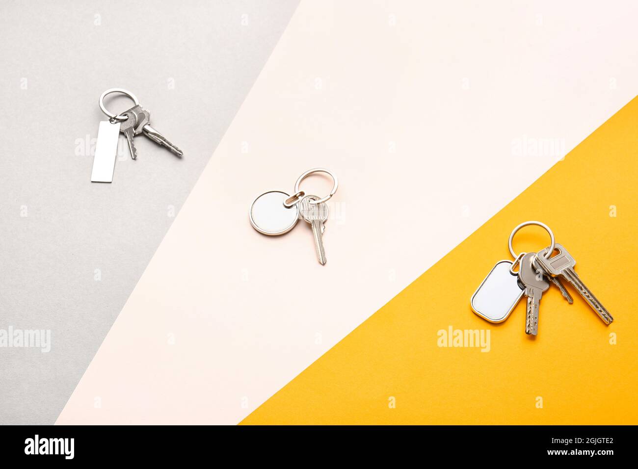 Keys with stylish keychains on color background Stock Photo - Alamy