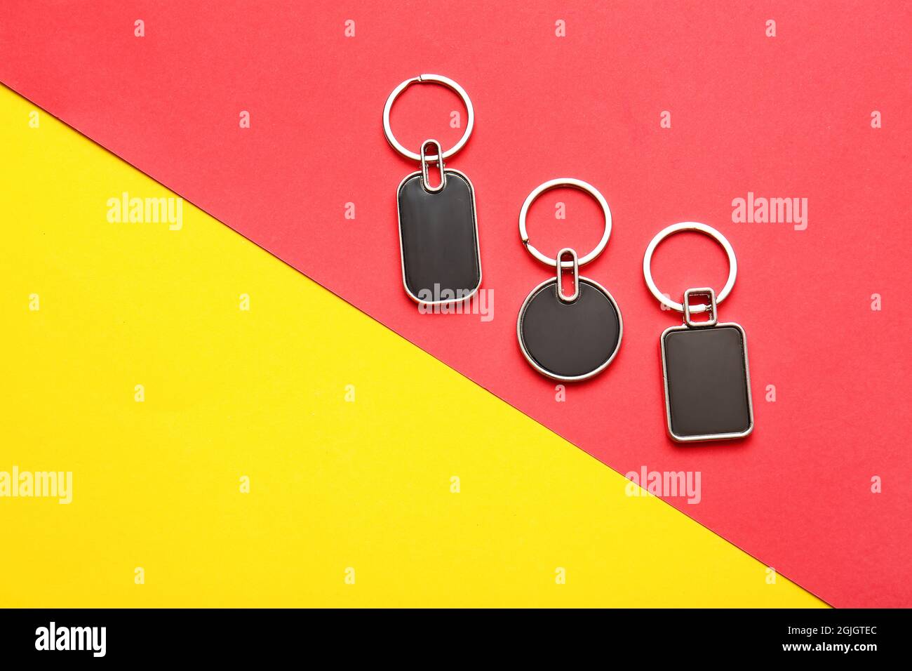Stylish keychains on color background Stock Photo - Alamy