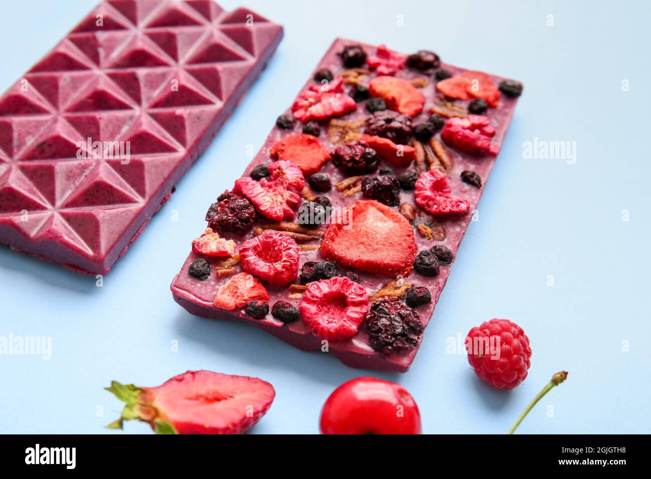 Handmade chocolate bars with fruits, berries and nuts on color ...