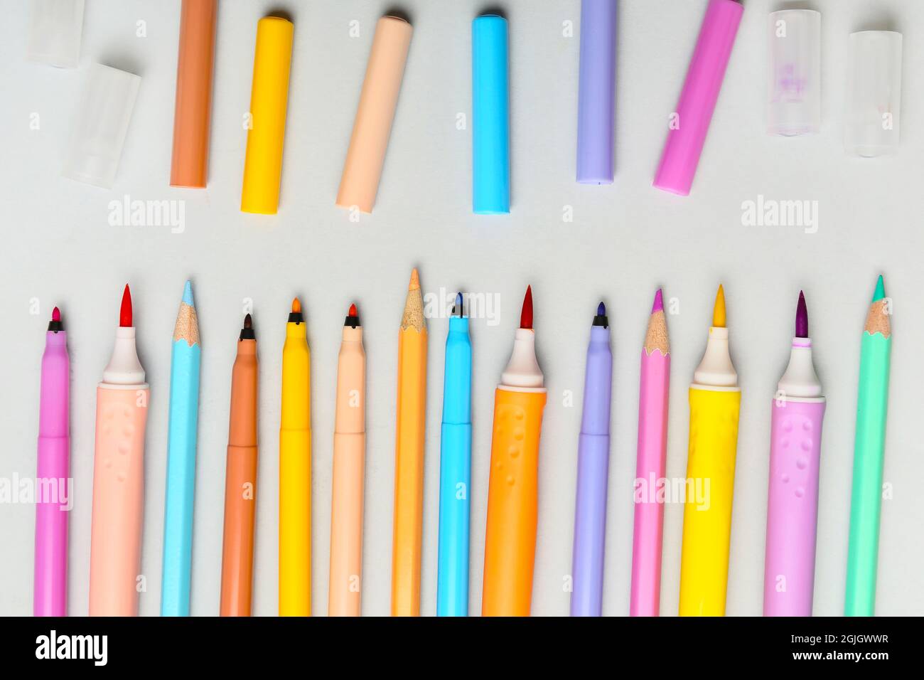 Colorful markers and pencils on light background Stock Photo - Alamy