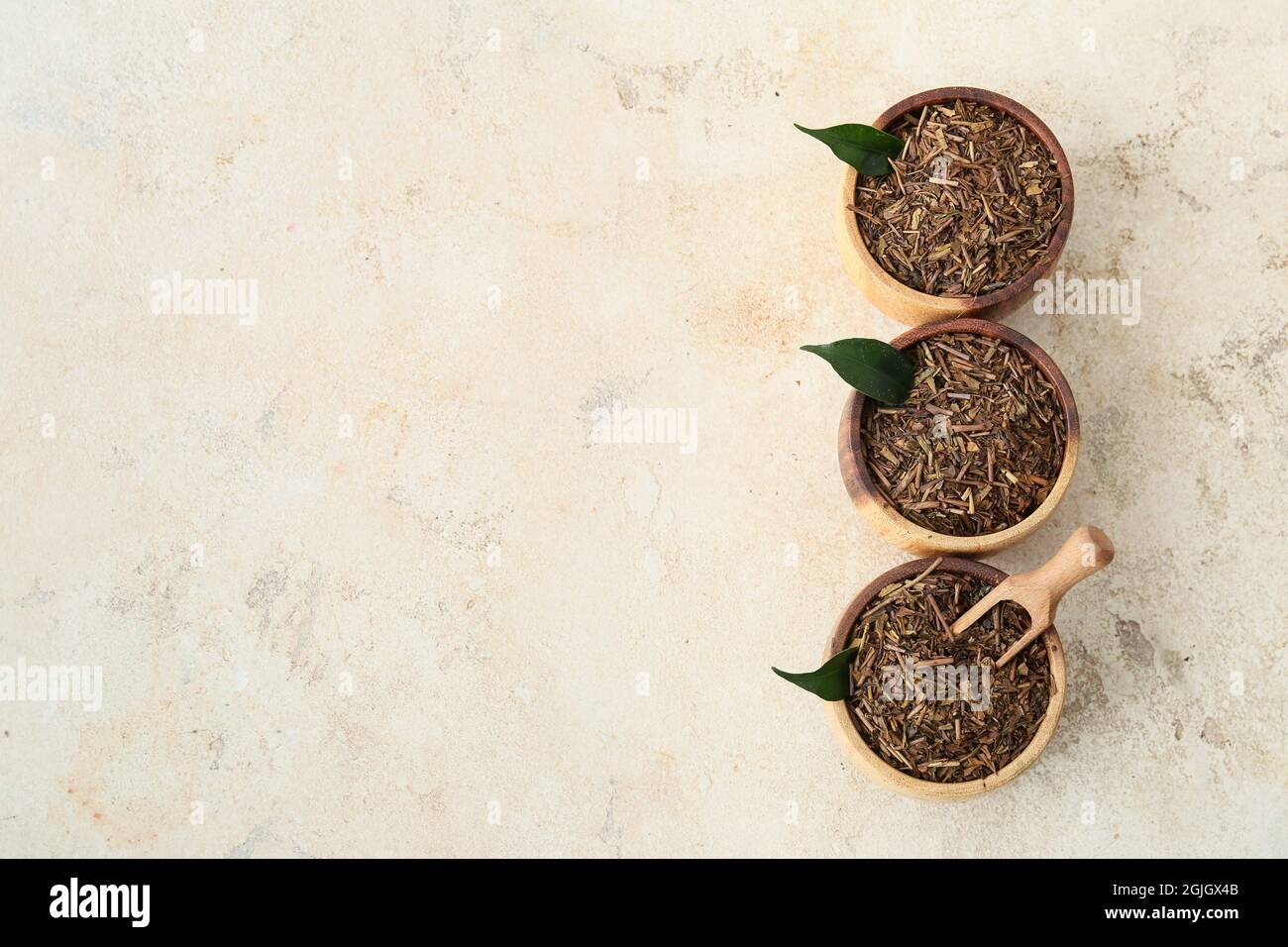Bowls of dry hojicha green tea on light background Stock Photo - Alamy