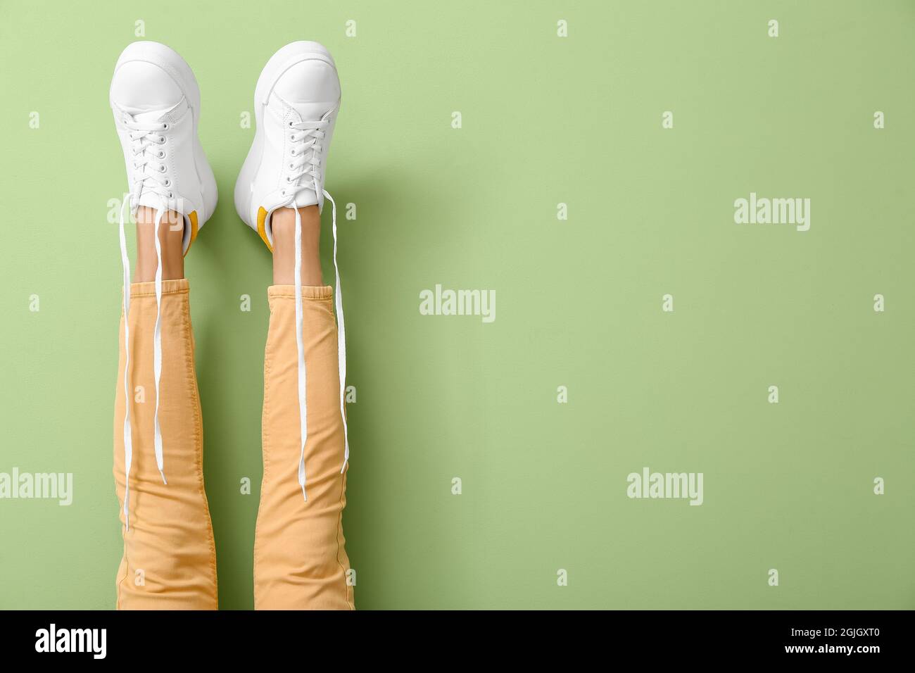 Legs of woman with undone shoe laces on color background Stock Photo ...