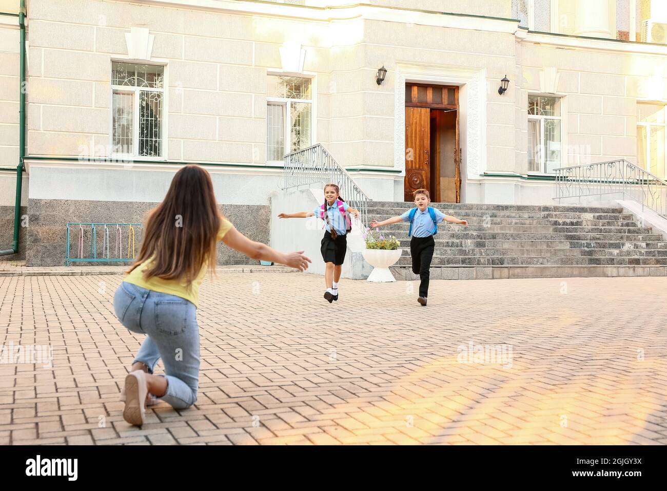 Mother meeting her little children after school Stock Photo - Alamy