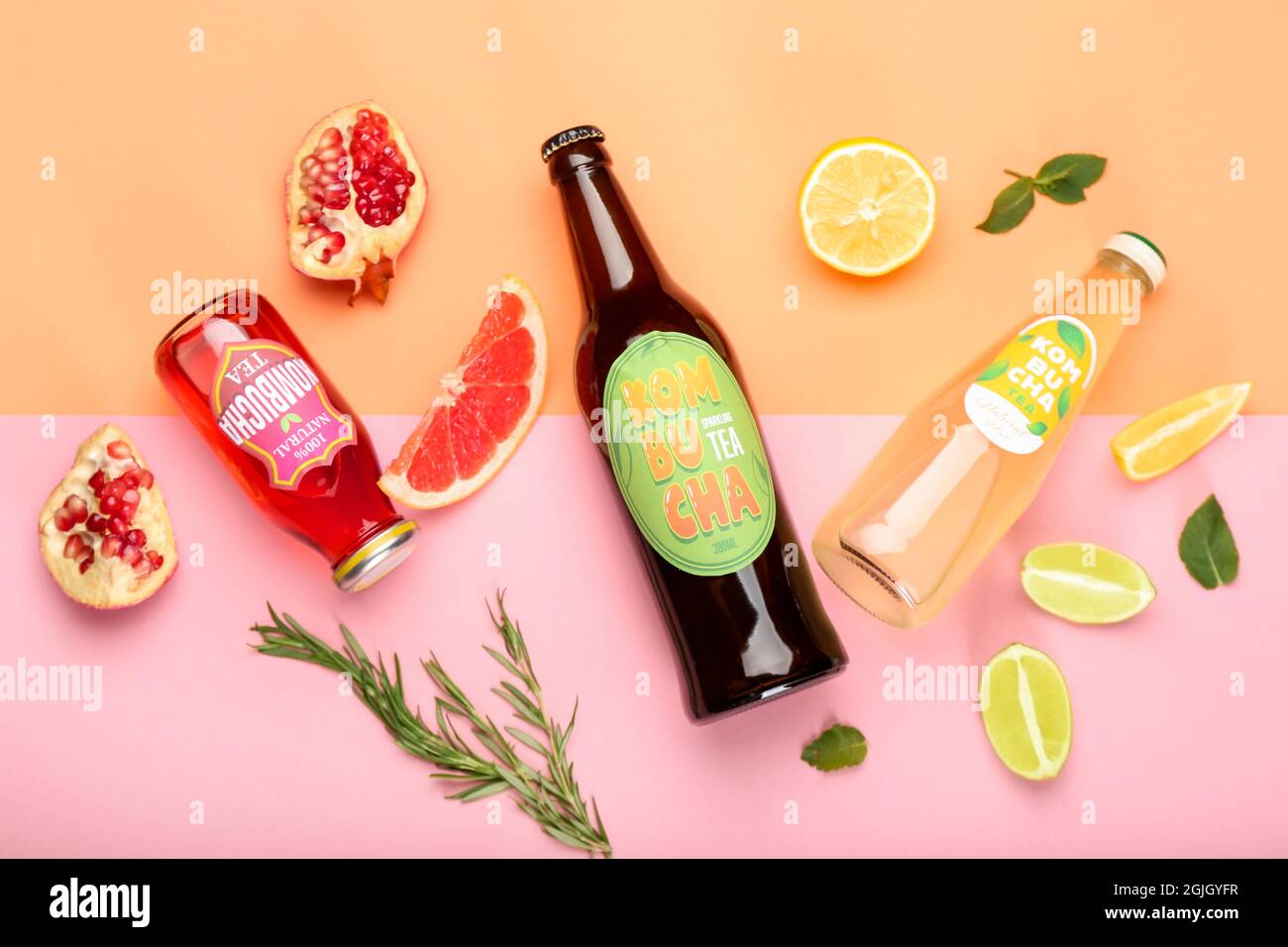 Composition with different kombucha tea in bottles and fruits on color ...