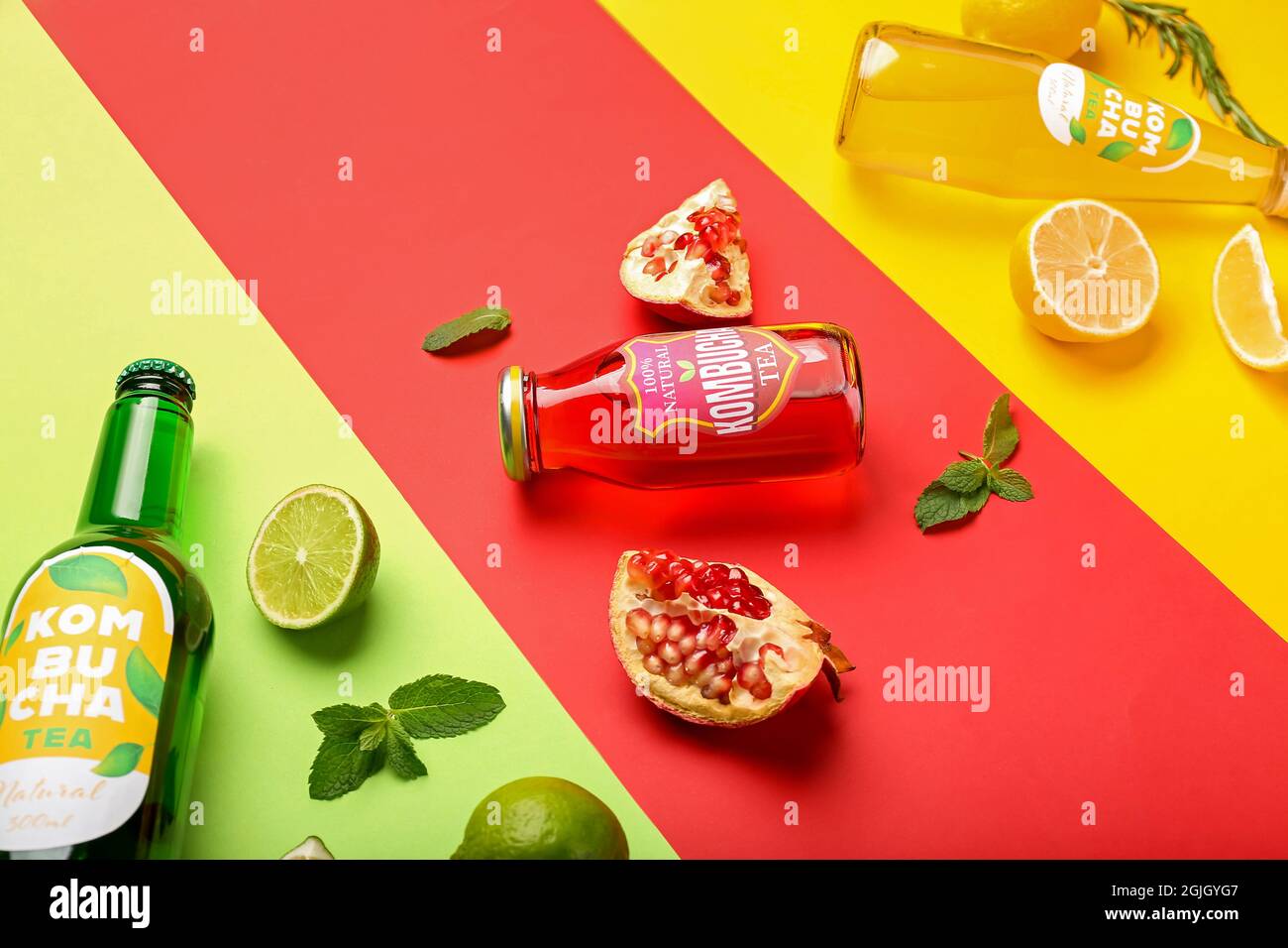 Bottles of different kombucha tea and fruits on color background Stock ...