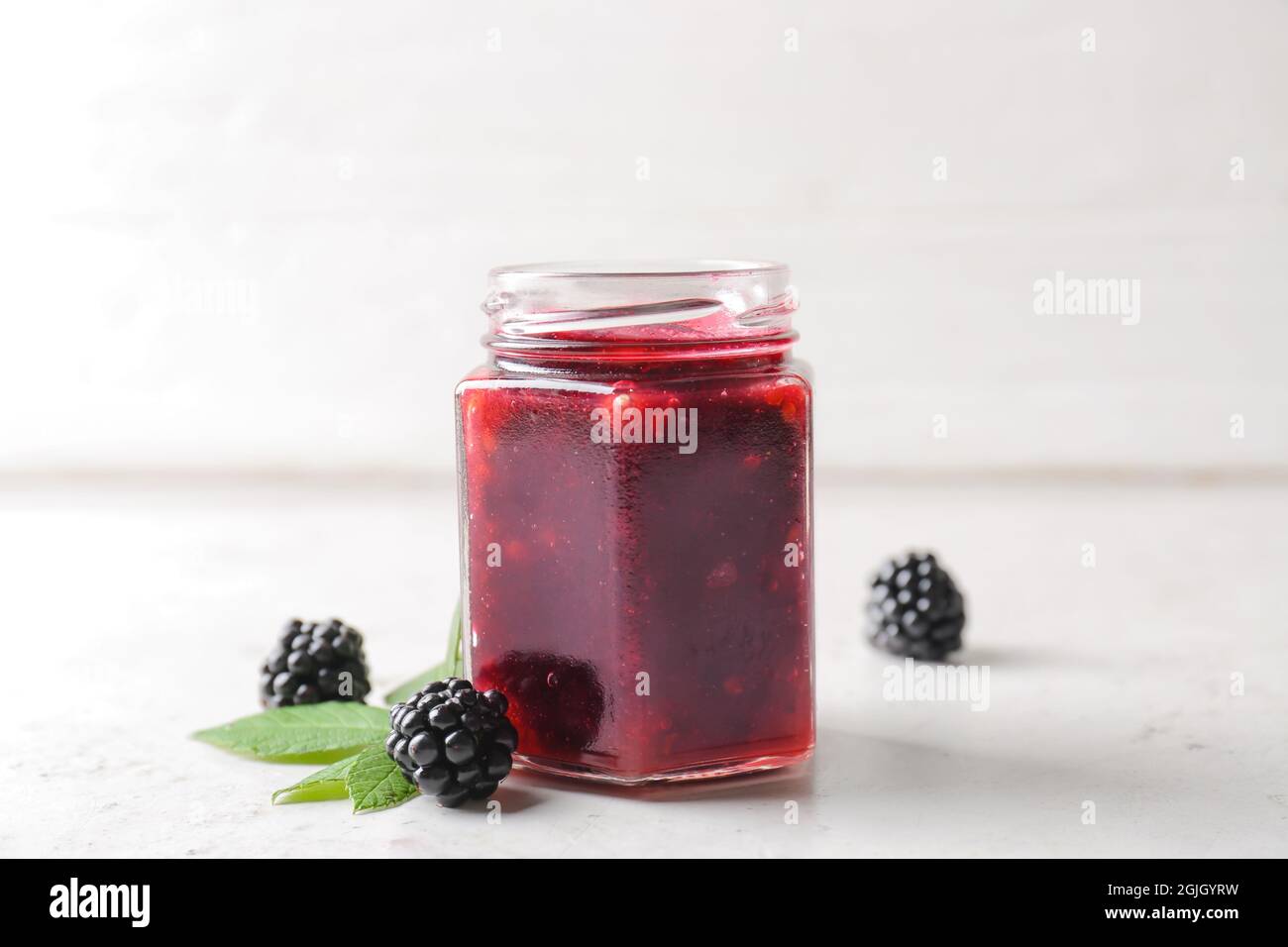 Jar of tasty blackberry jam on light background Stock Photo - Alamy