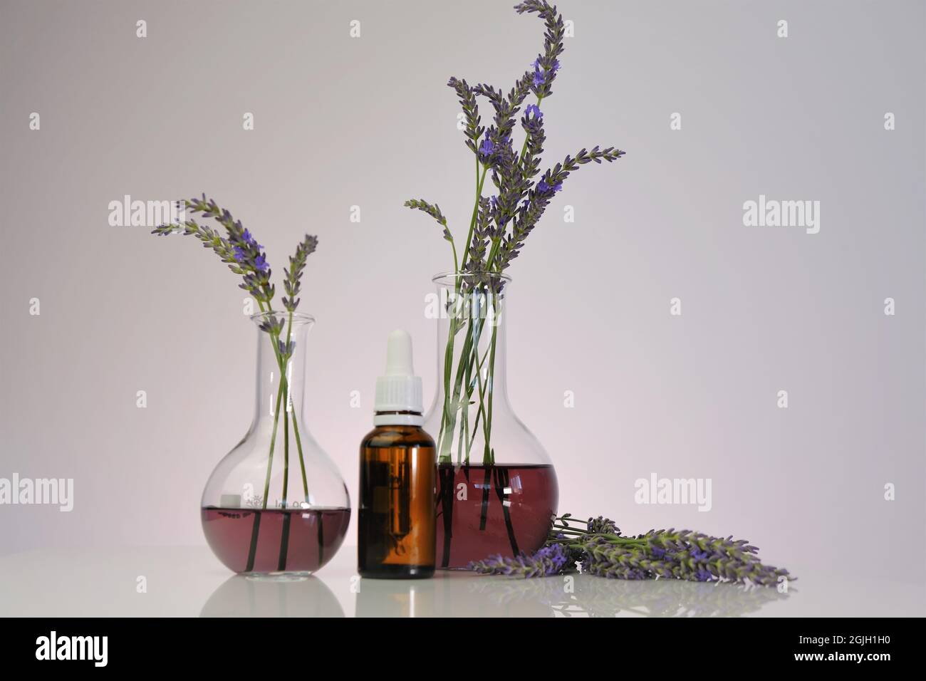 Lavender Essential oil. bottle with a pipette, laboratory flasks with ...