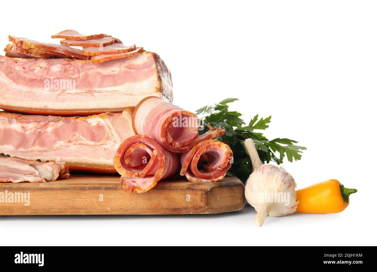 Wooden board with tasty smoked bacon and fresh vegetables on white ...