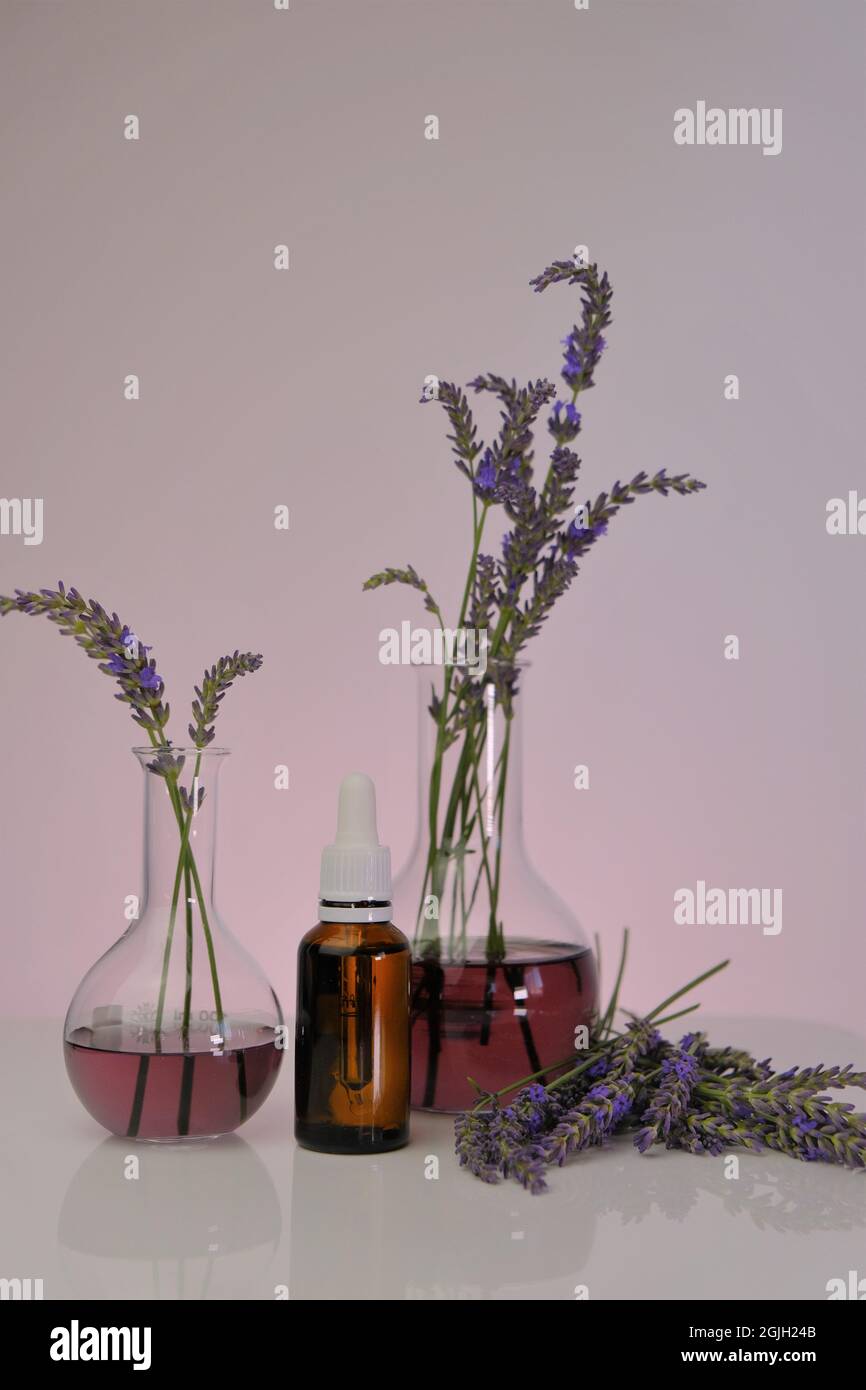 Lavender oil.Glass bottle with a pipette, laboratory flasks with ...
