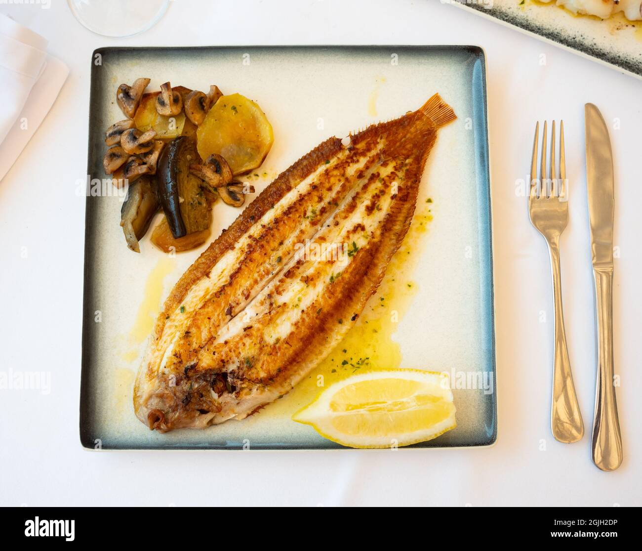 Fried sole fish with baked vegetables and lemon Stock Photo - Alamy