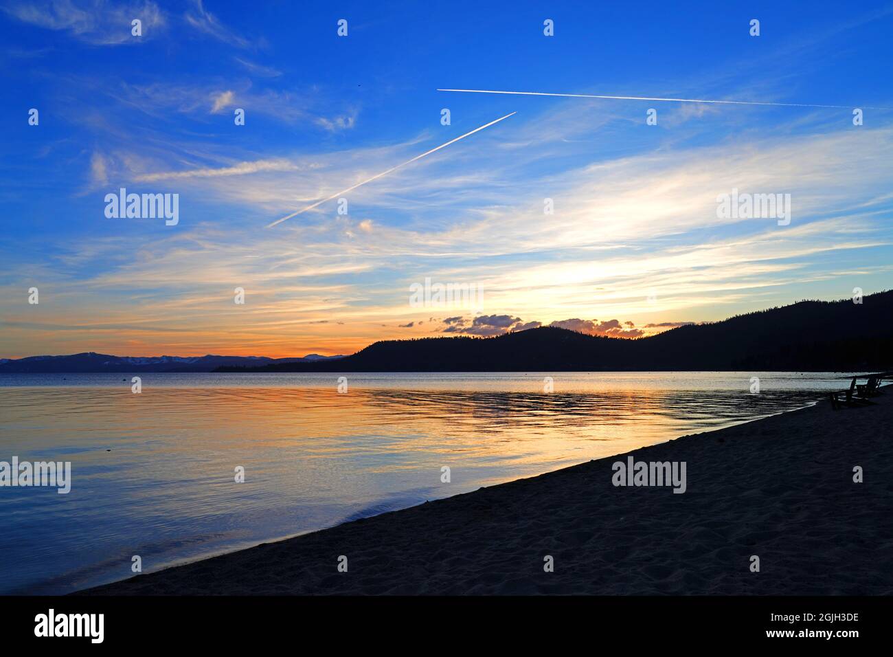 Landscape view of a sunset sky over Lake Tahoe with snow-covered ...