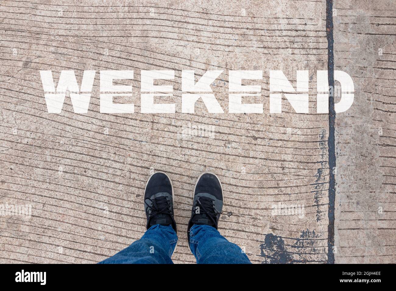 A weekend concept, a man wears black shoes on a concrete pavement with ...