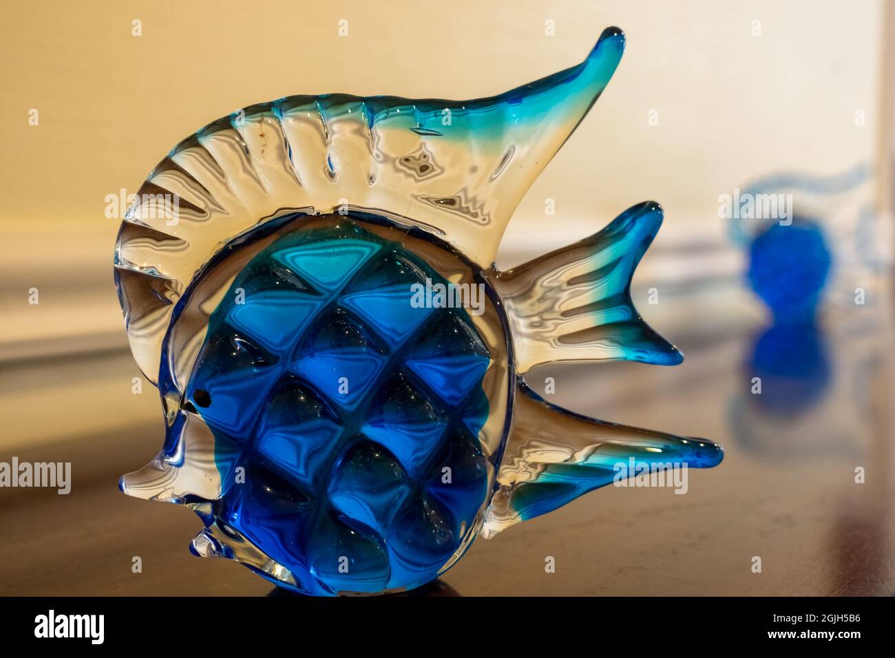 Fish-shaped glass statue on a table Stock Photo - Alamy