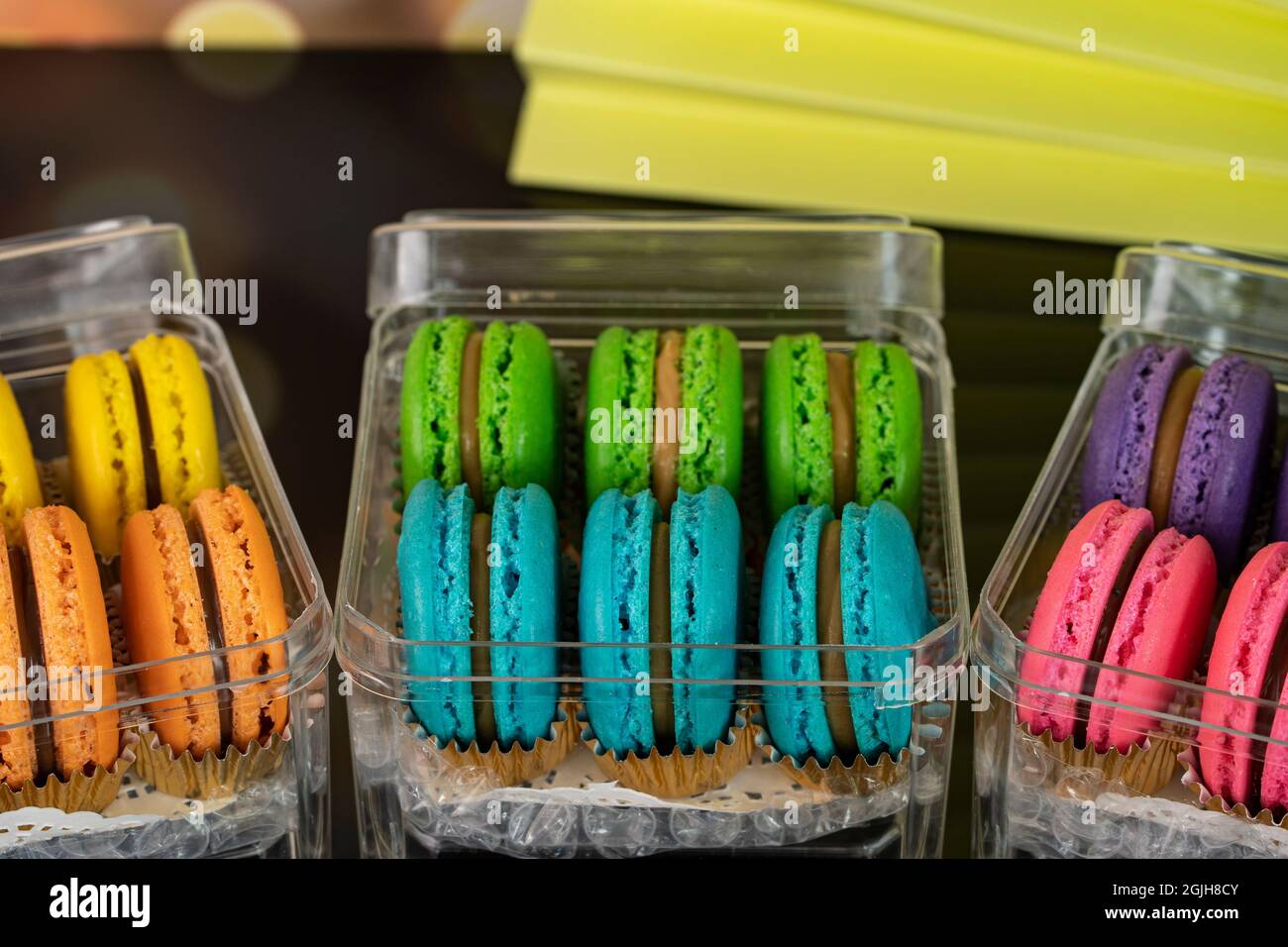 Delicious macaroons, a famous French dessert in clear box for sale. Selective focus. Blurred ...