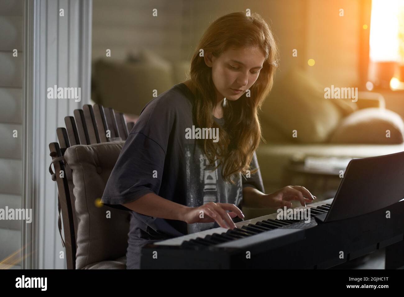 A young woman playing the piano.Close-up of a beautiful blonde girl ...