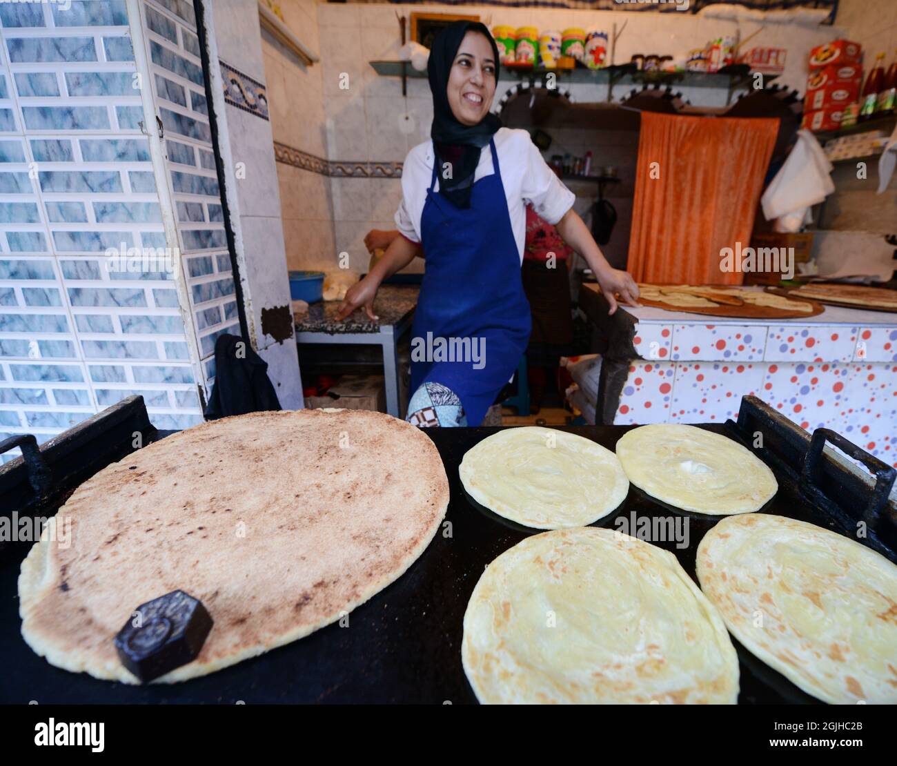 Moroccan women preparing traditional Moroccan bread in a small shop at ...