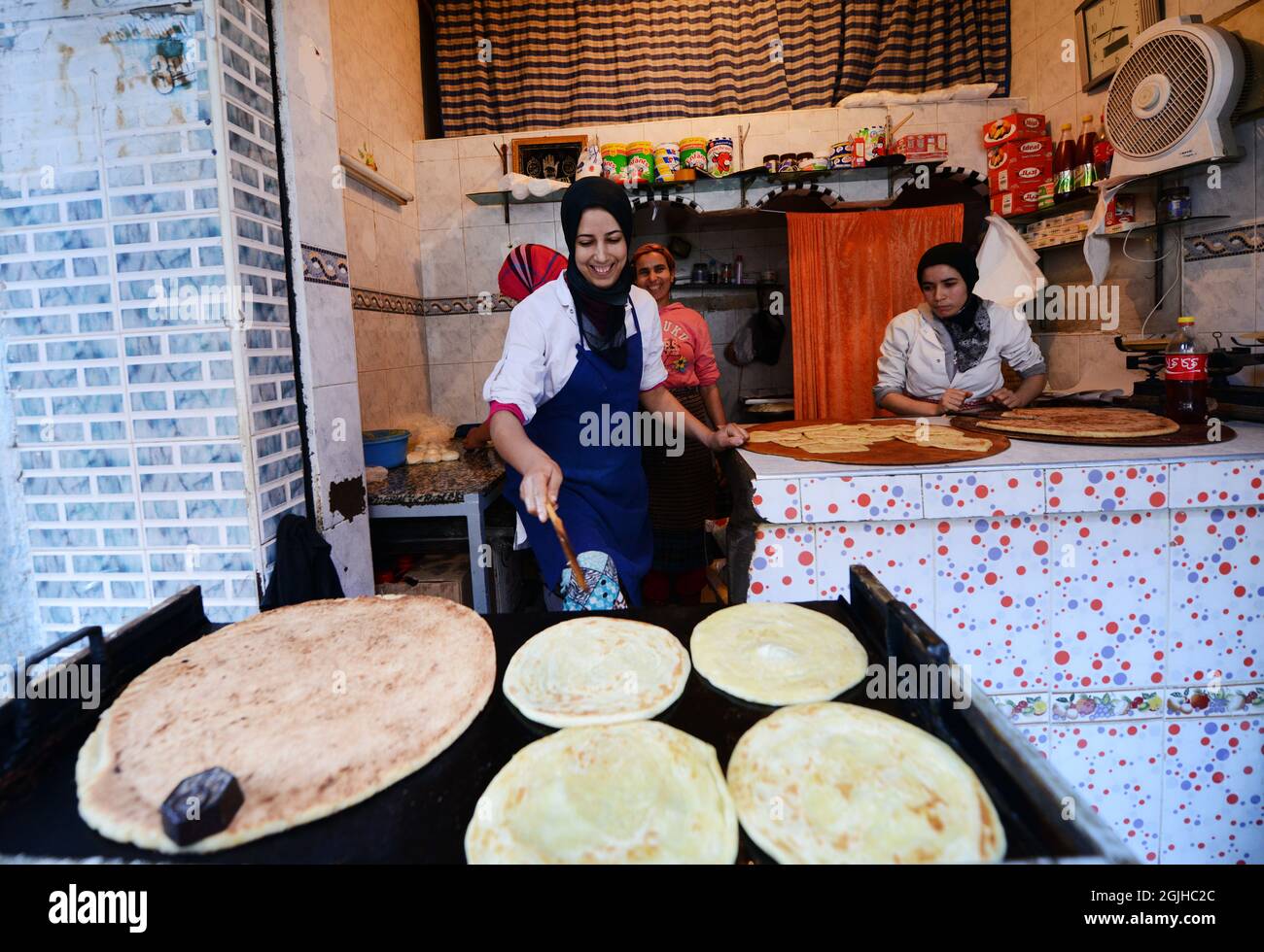 Moroccan women preparing traditional Moroccan bread in a small shop at ...
